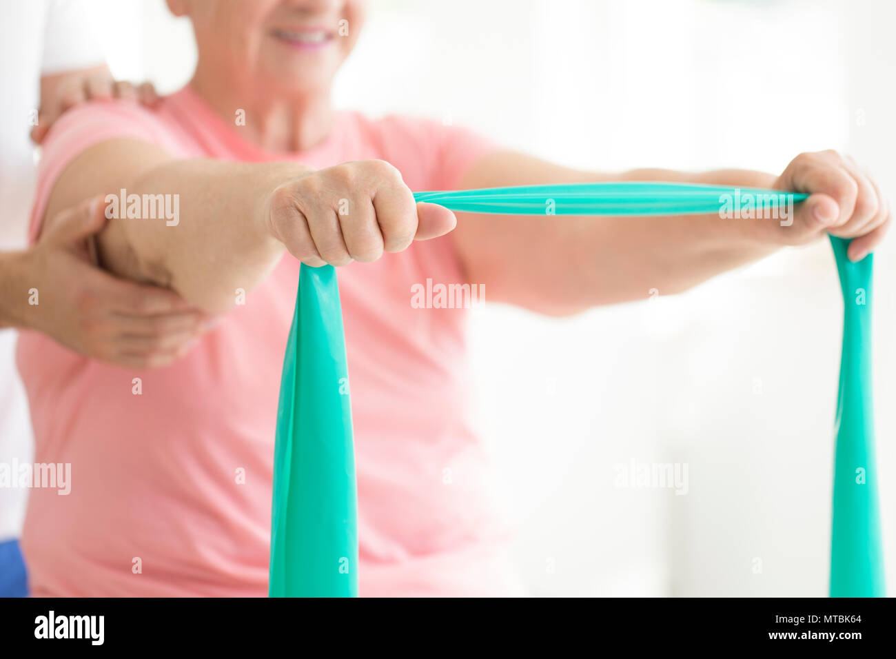 Senior woman holding a teal scarf in her hands while performing active ...