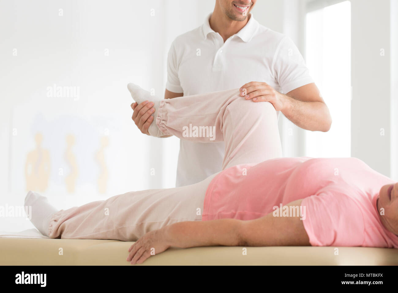 Physical therapist improving joints condition of his elderly ward ...