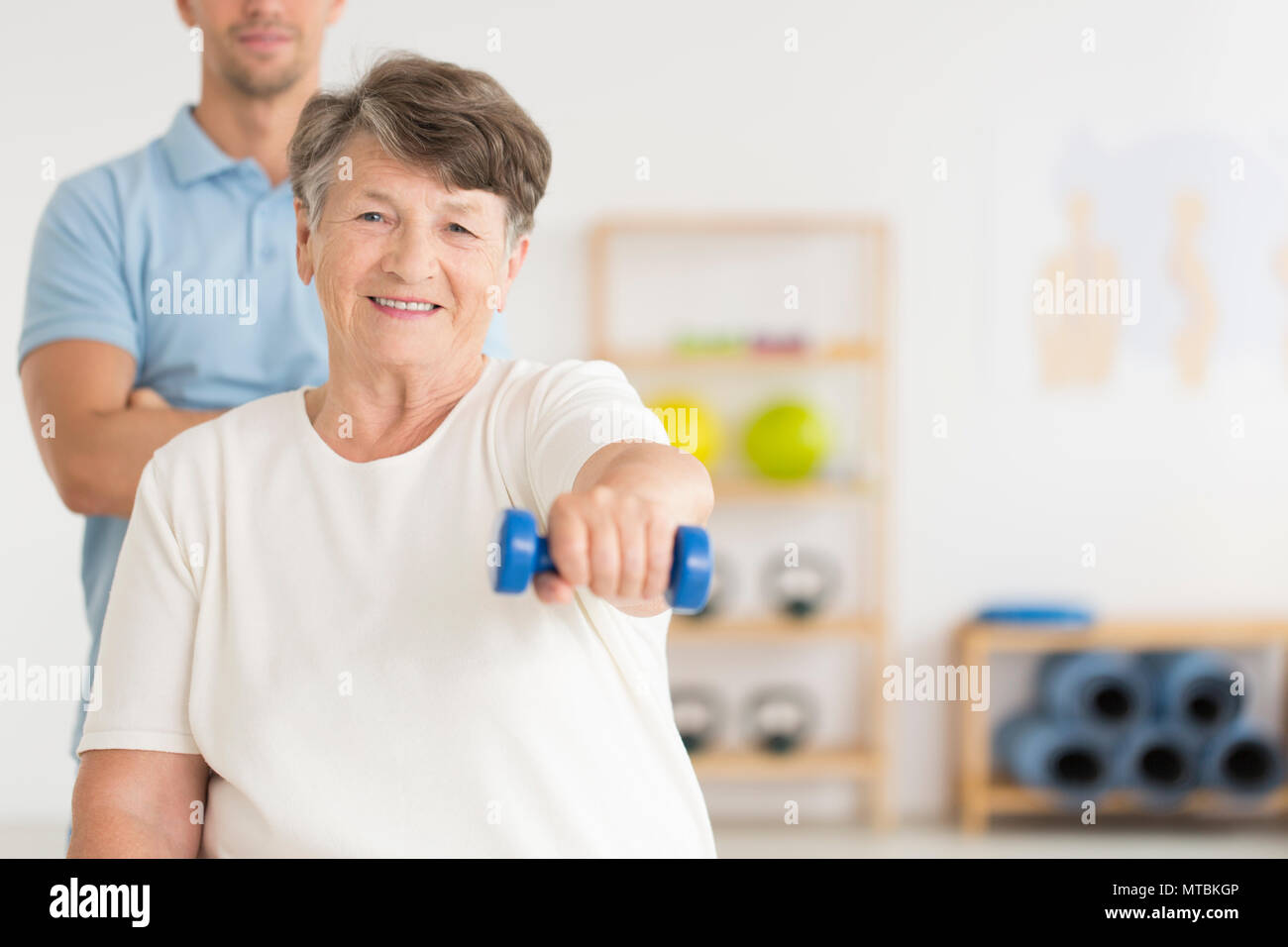 Elderly woman doing active, isometric exercises guided by physical ...