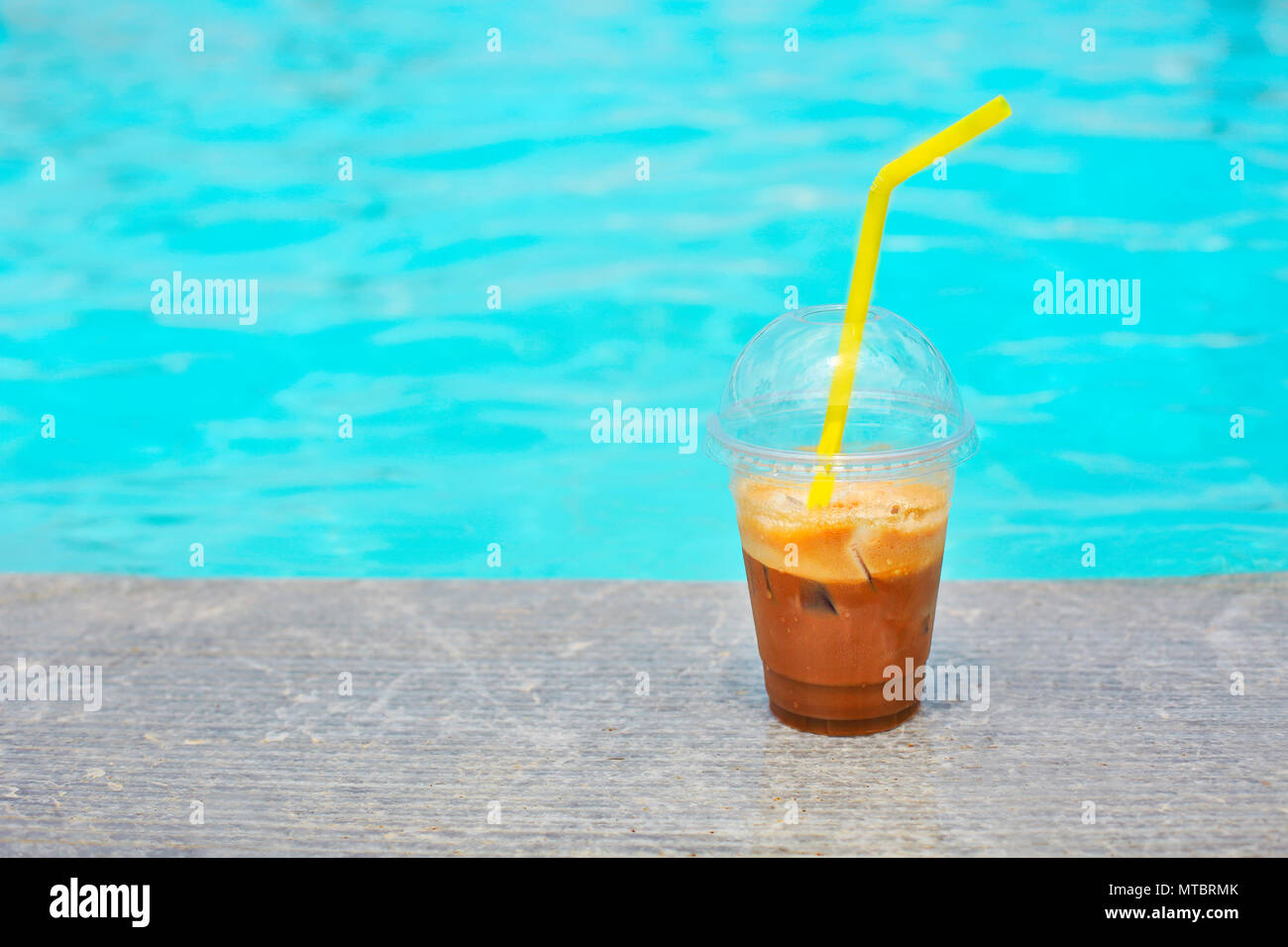 Iced coffee glass on outdoor poolside Stock Photo - Alamy