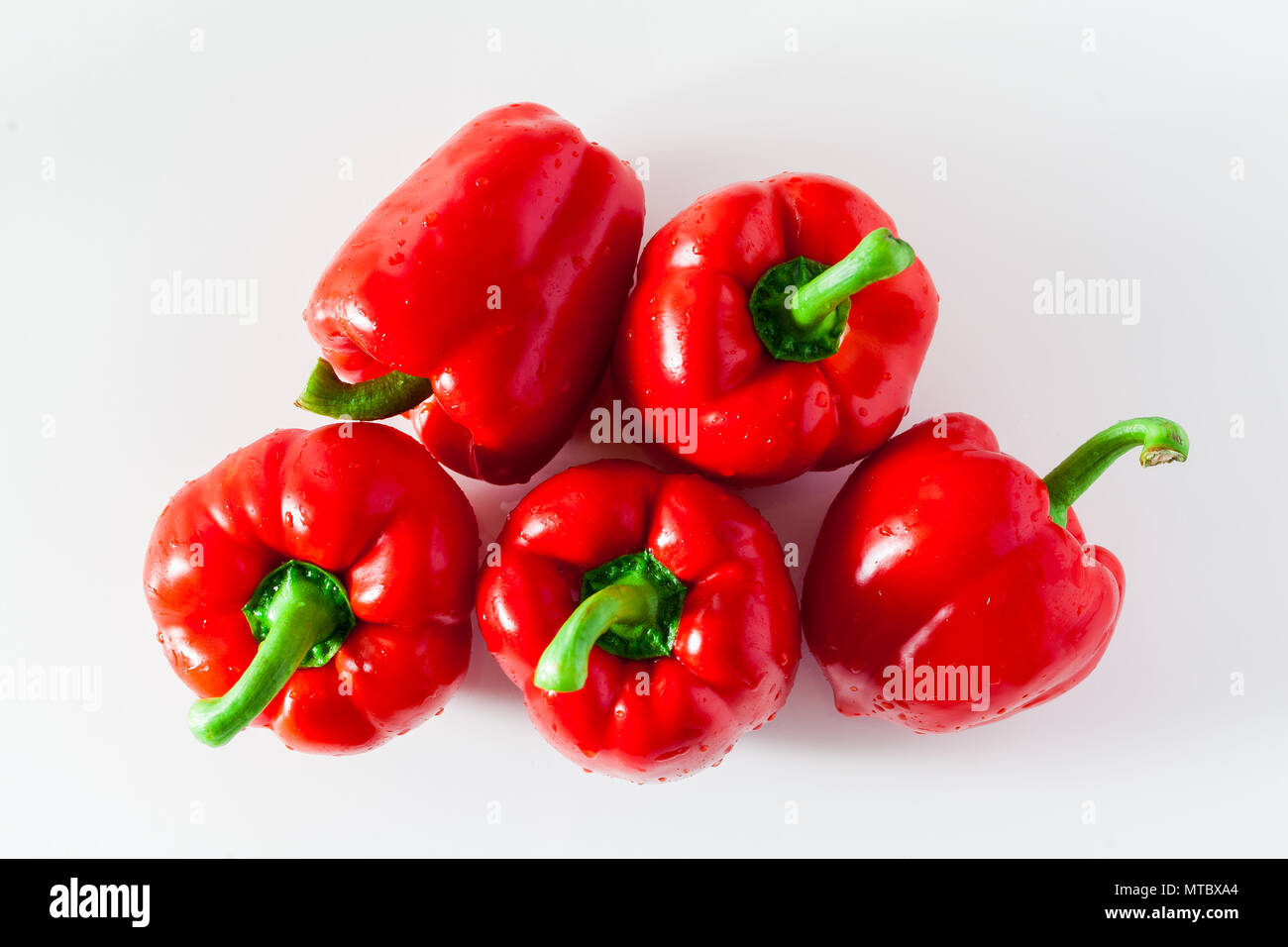 group of red ripe organic bell pepper and fresh basil leaves isolated ...