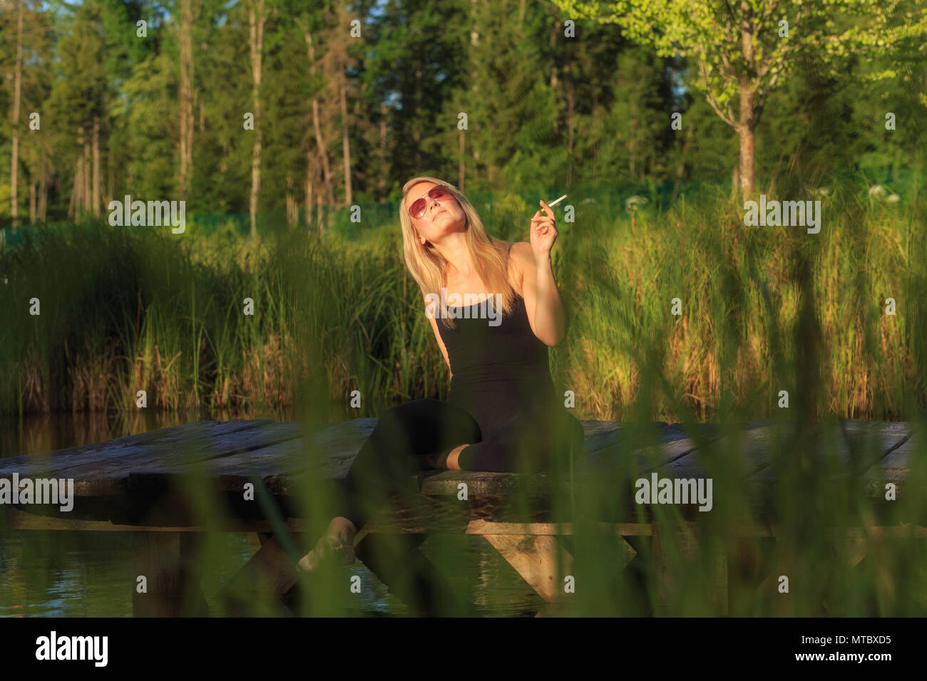 A dancer makes cigarette break on a boat dock Stock Photo - Alamy