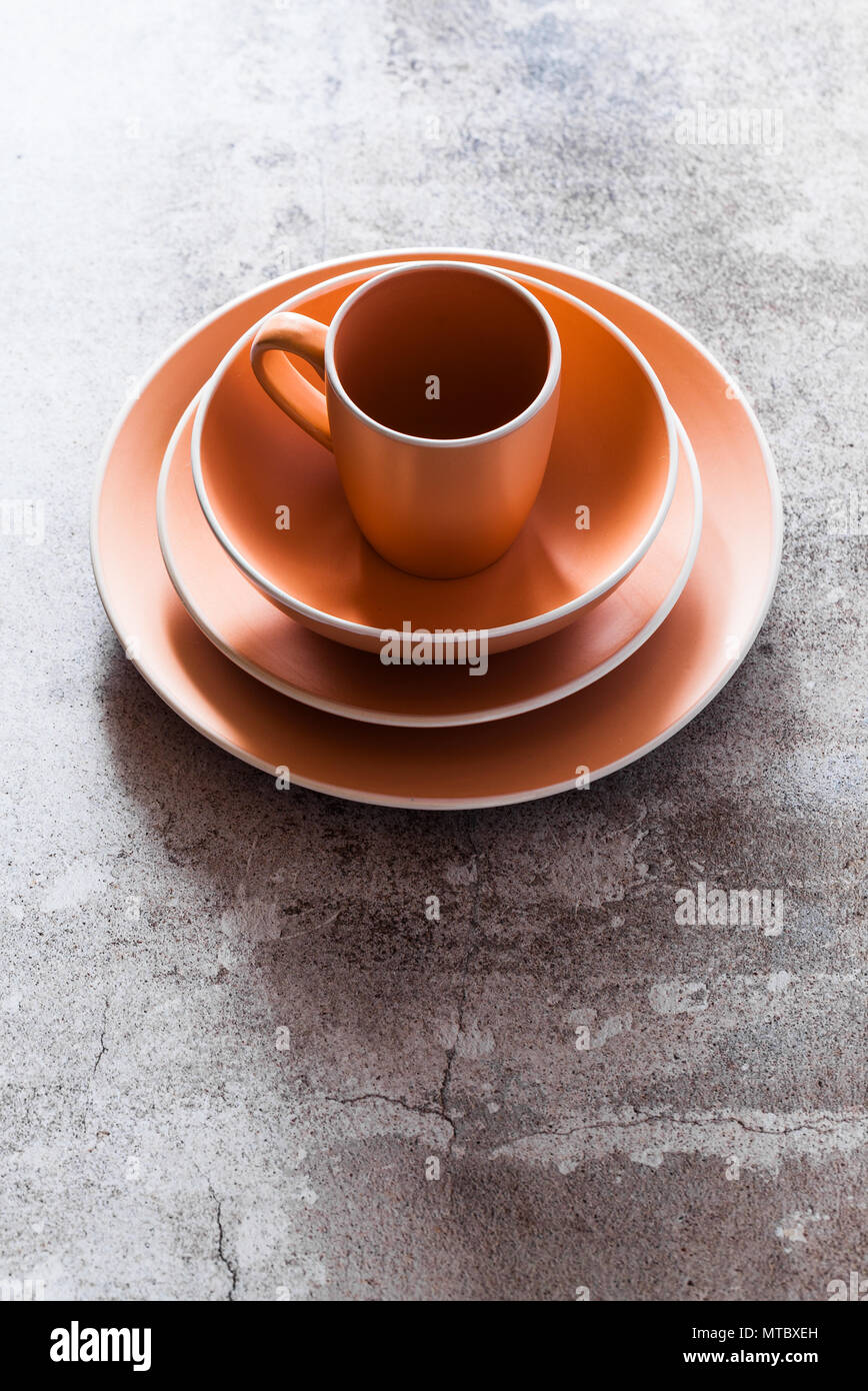 set of plates and a mug on a gray stone table. copy space. modern ...