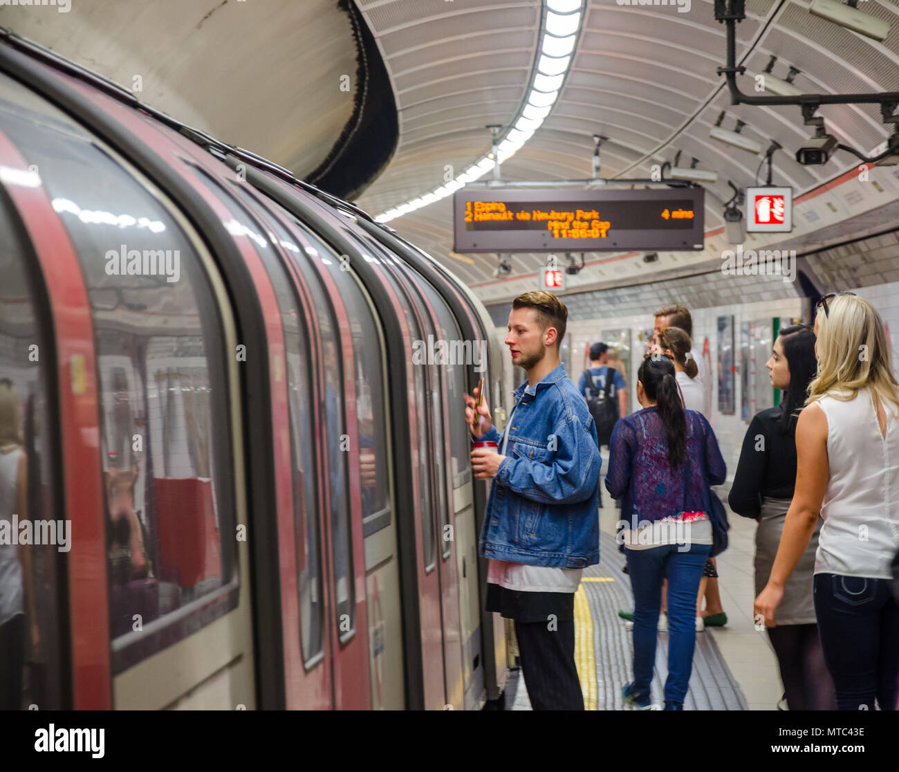 A male passenger boards a London Underground train at Shepherd's Bush ...