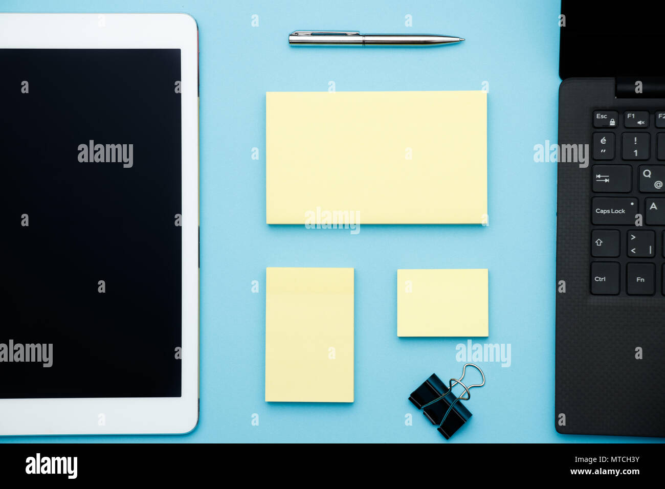 Overhead of office table with laptop, computer keyboard, tablet pc and ...
