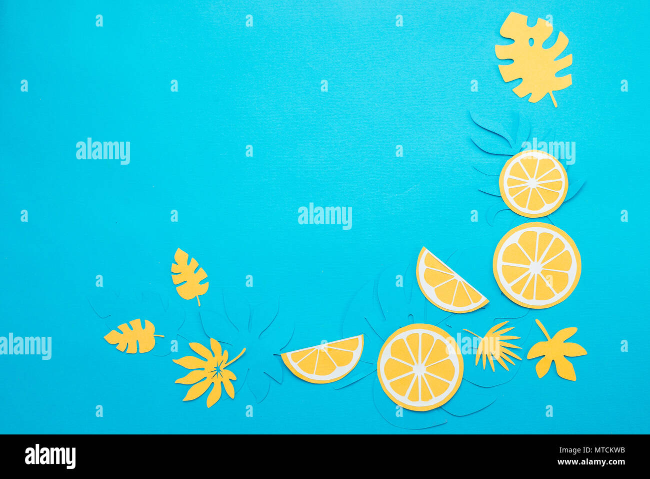 Lemon slices and tropical leaves pattern on a bright blue background ...