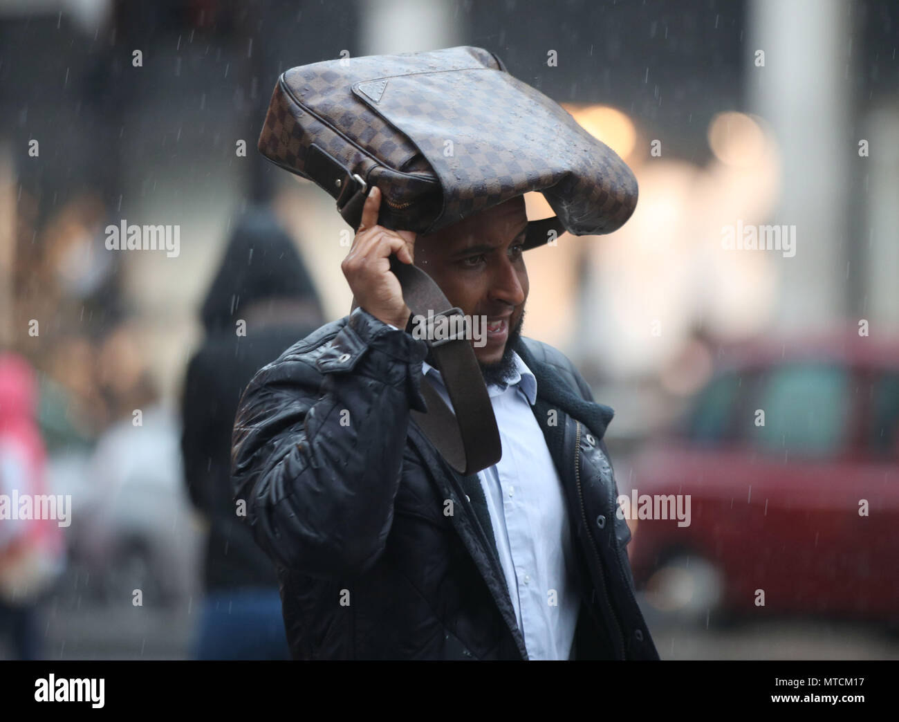 People caught in the rain on Oxford Street, central London as ...