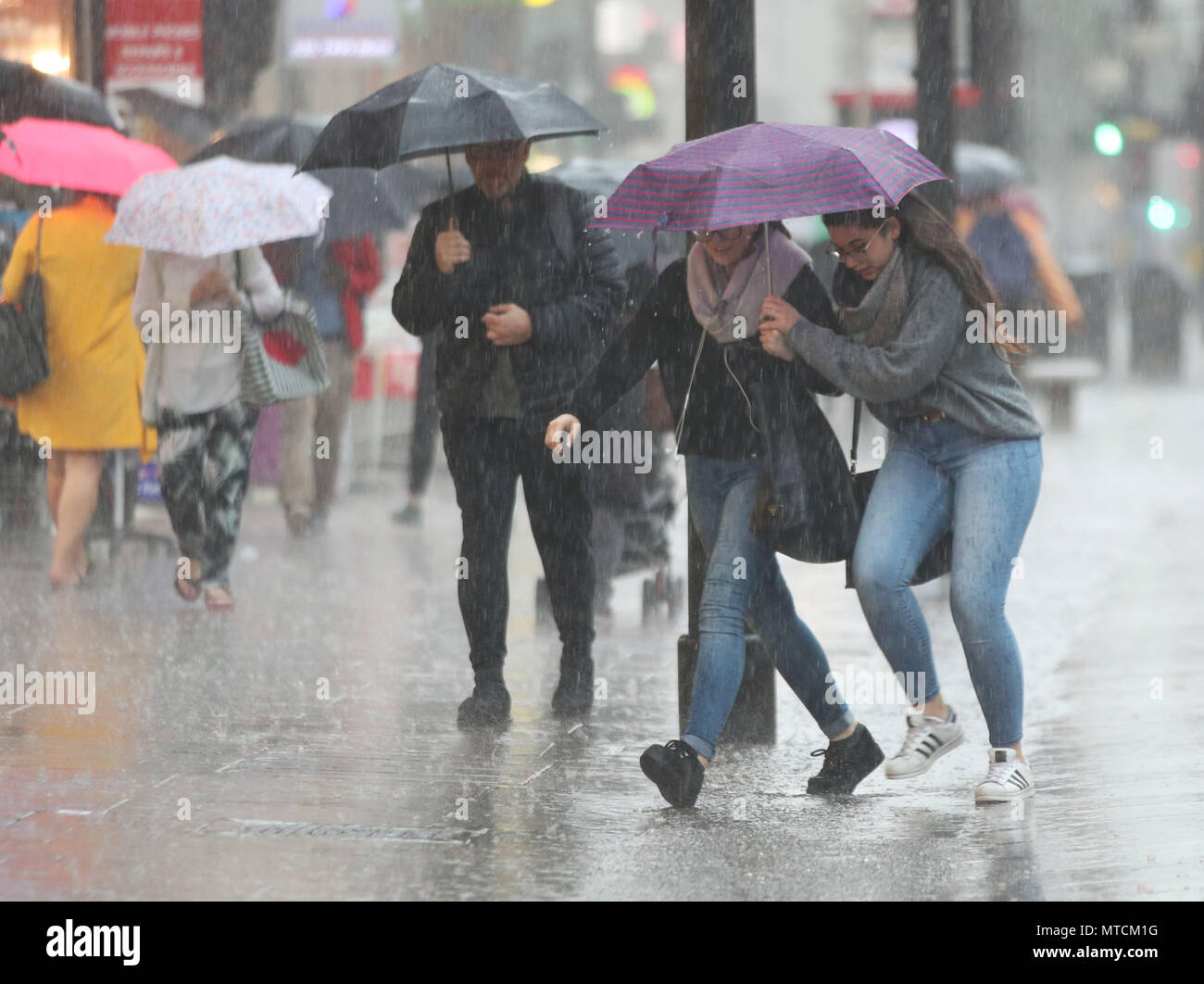 People caught in the rain on Oxford Street, central London as ...