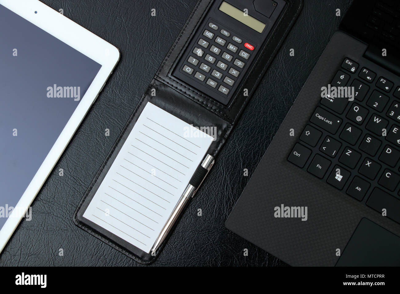 Cross overhead of office table with notebook, computer keyboard, tablet ...