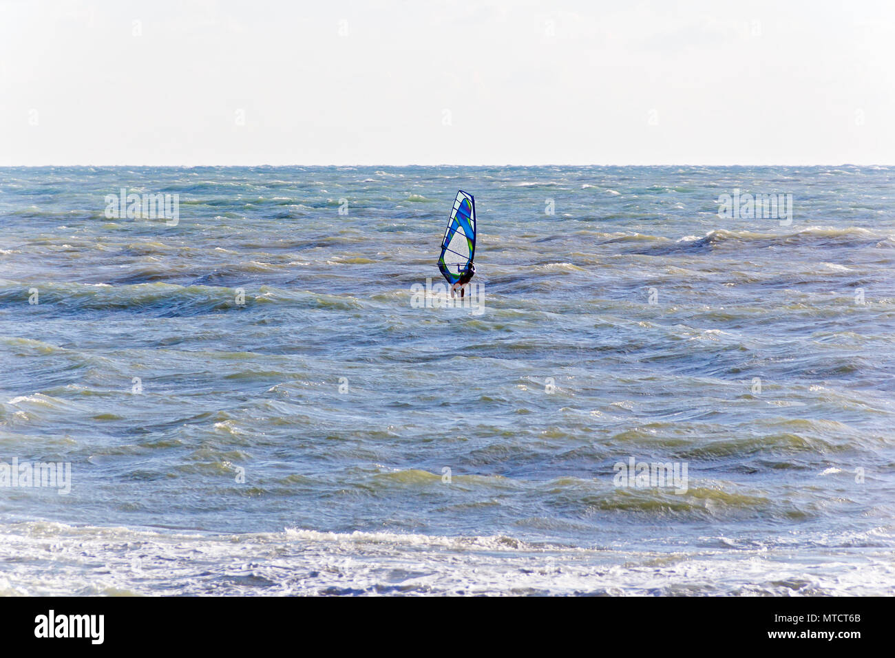 Horizontal photo of one surfer in open choppy sea Stock Photo - Alamy