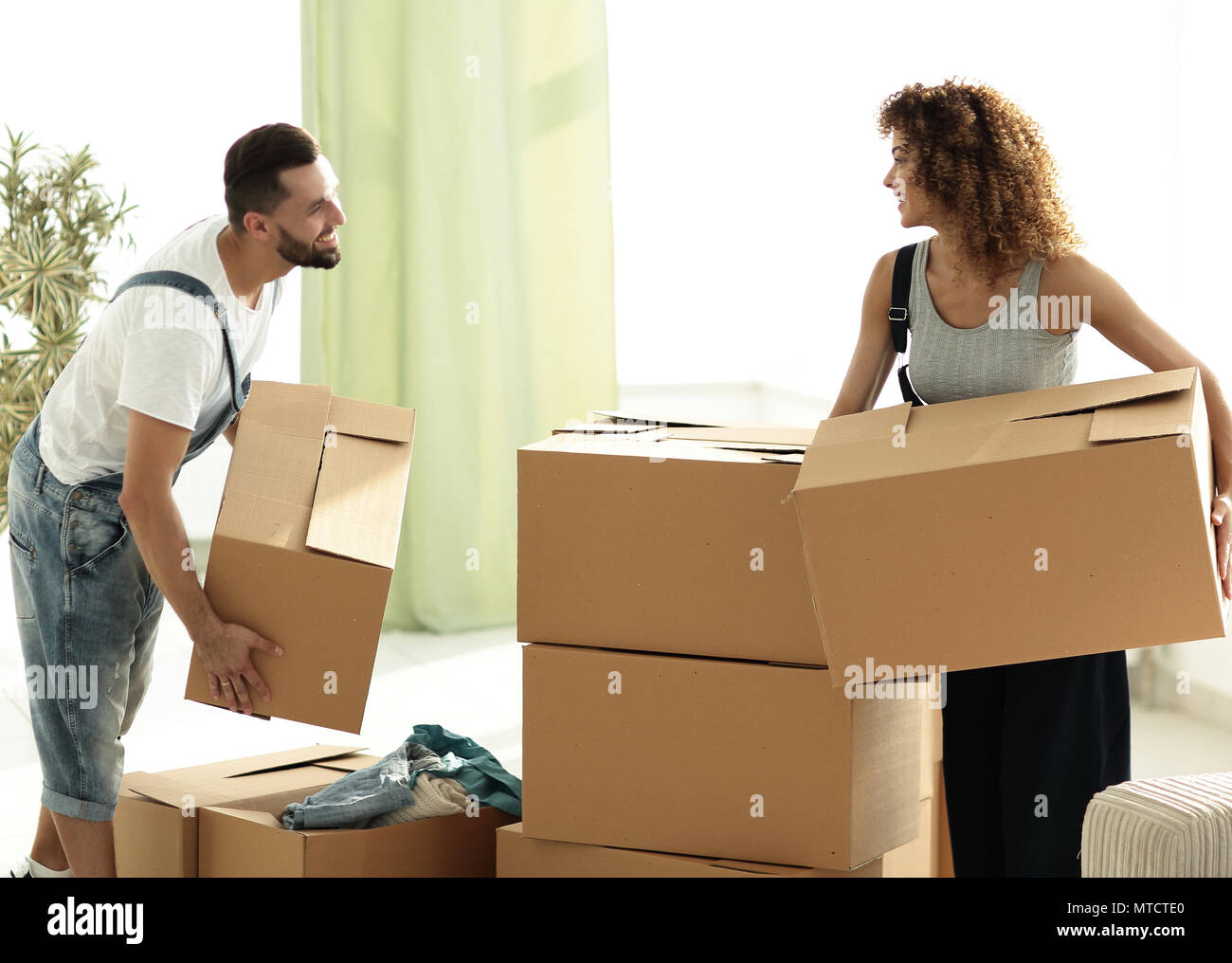 Young family unpacking boxes in a new house Stock Photo - Alamy