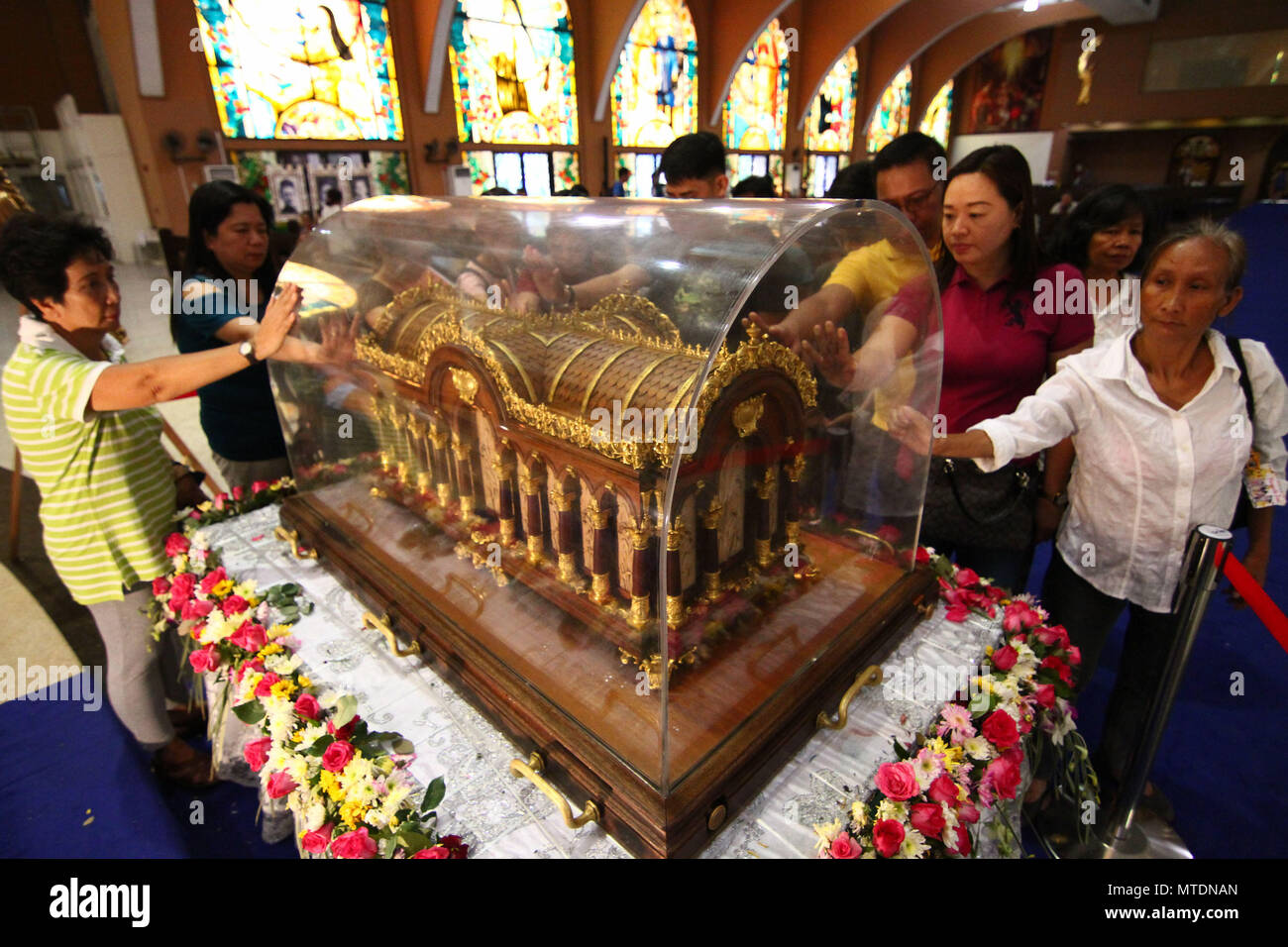 Catholic devotees seen touching the Shrine of Saint Therese of the ...