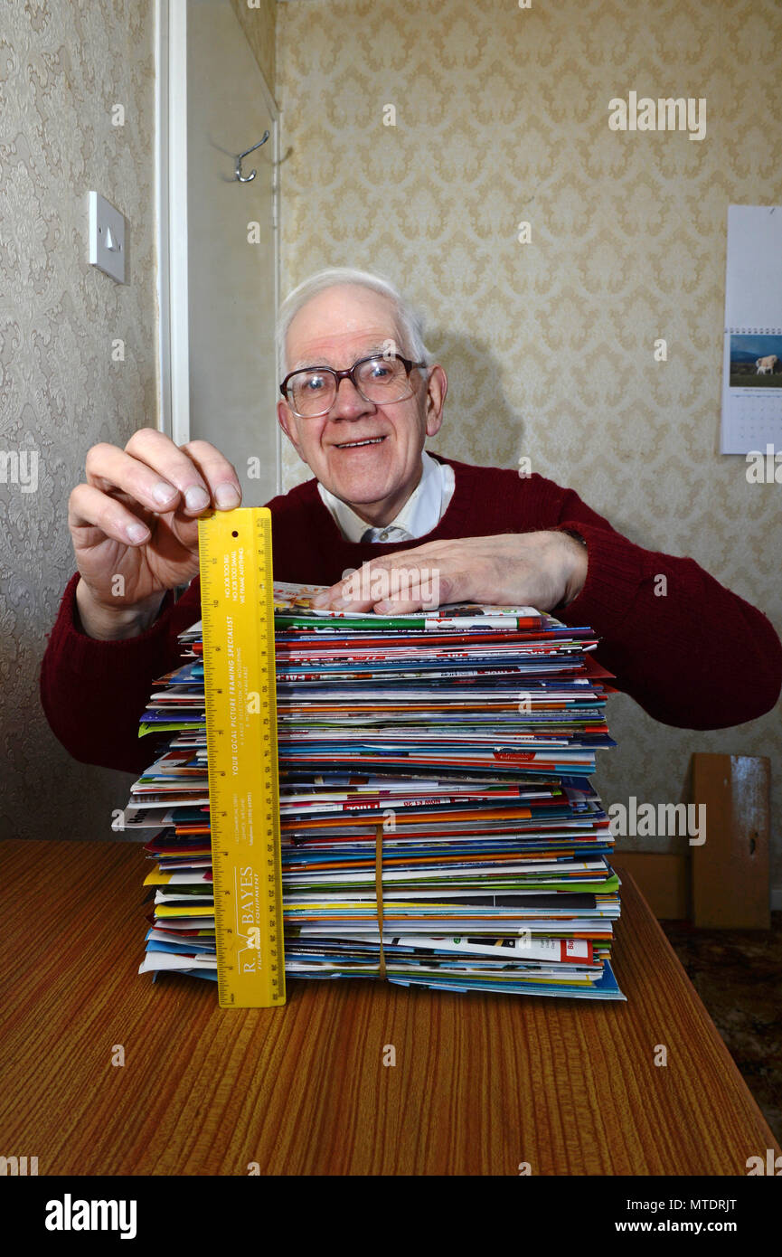 Old man with a pile of junk mail he has collected that was delivered ...