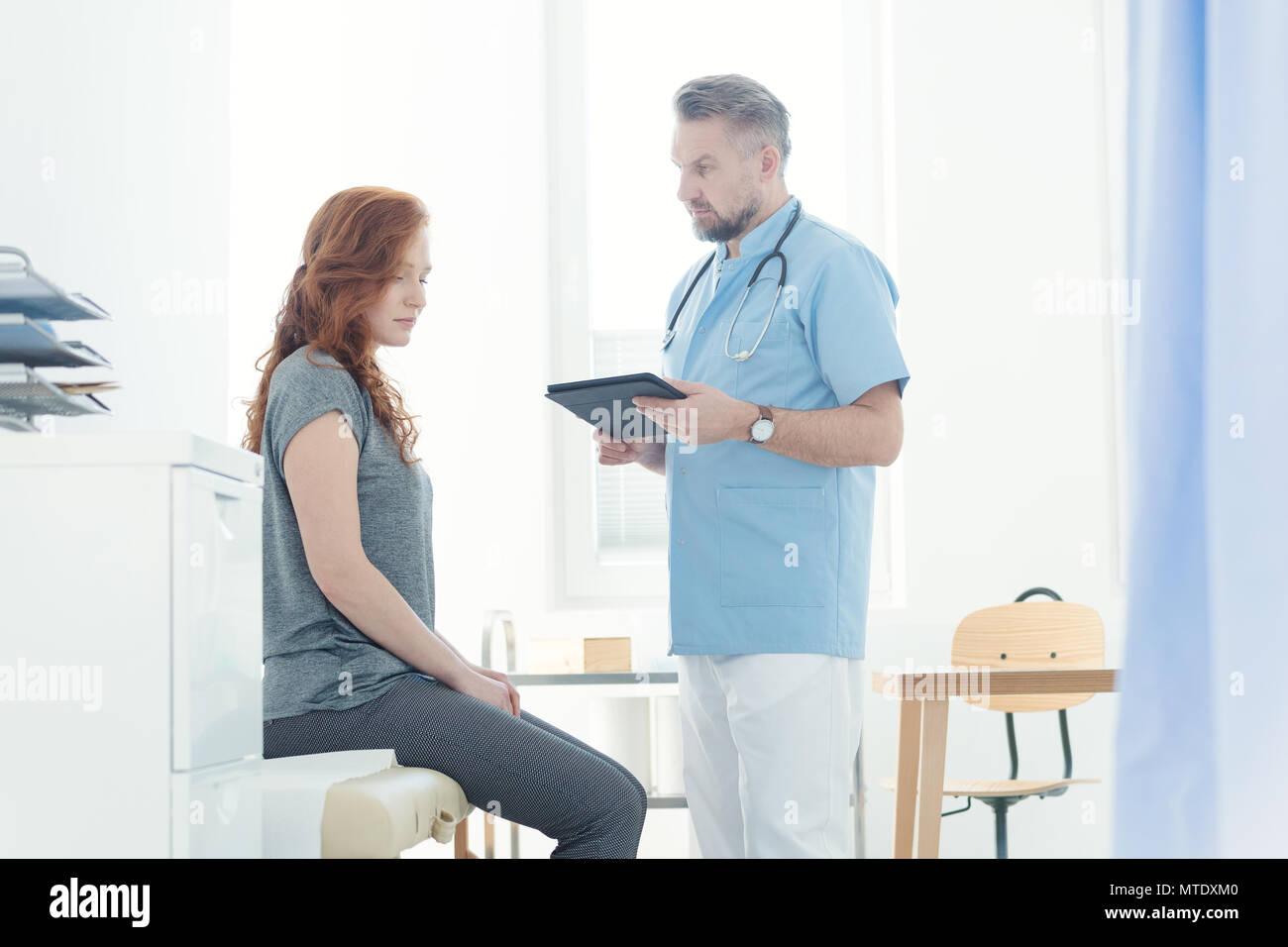 Doctor diagnosing a female patient with headache in a hospital Stock ...
