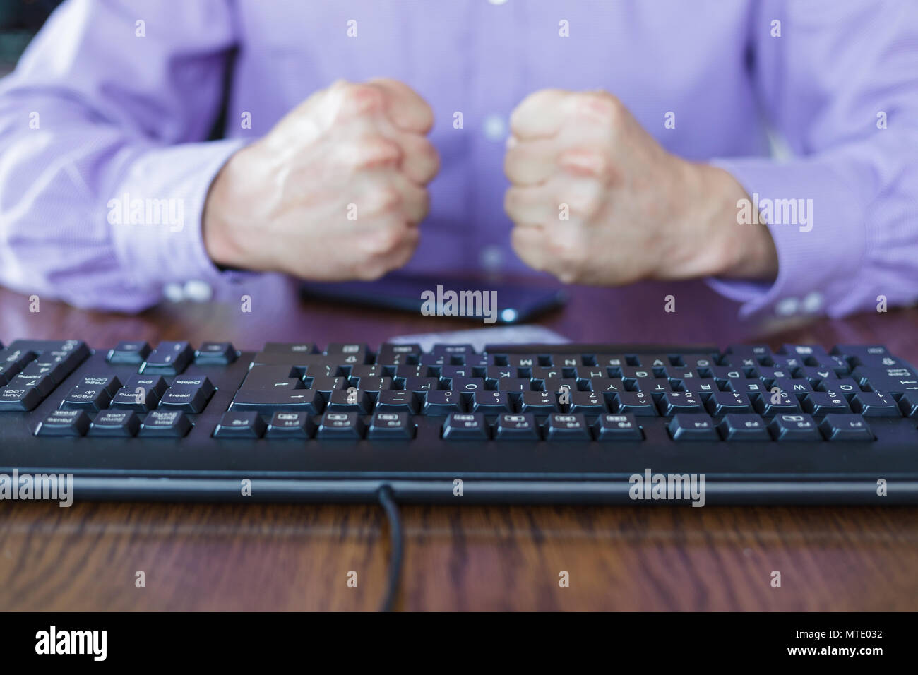 Agression in the Internet, man sitting behind keyboard with hands ...