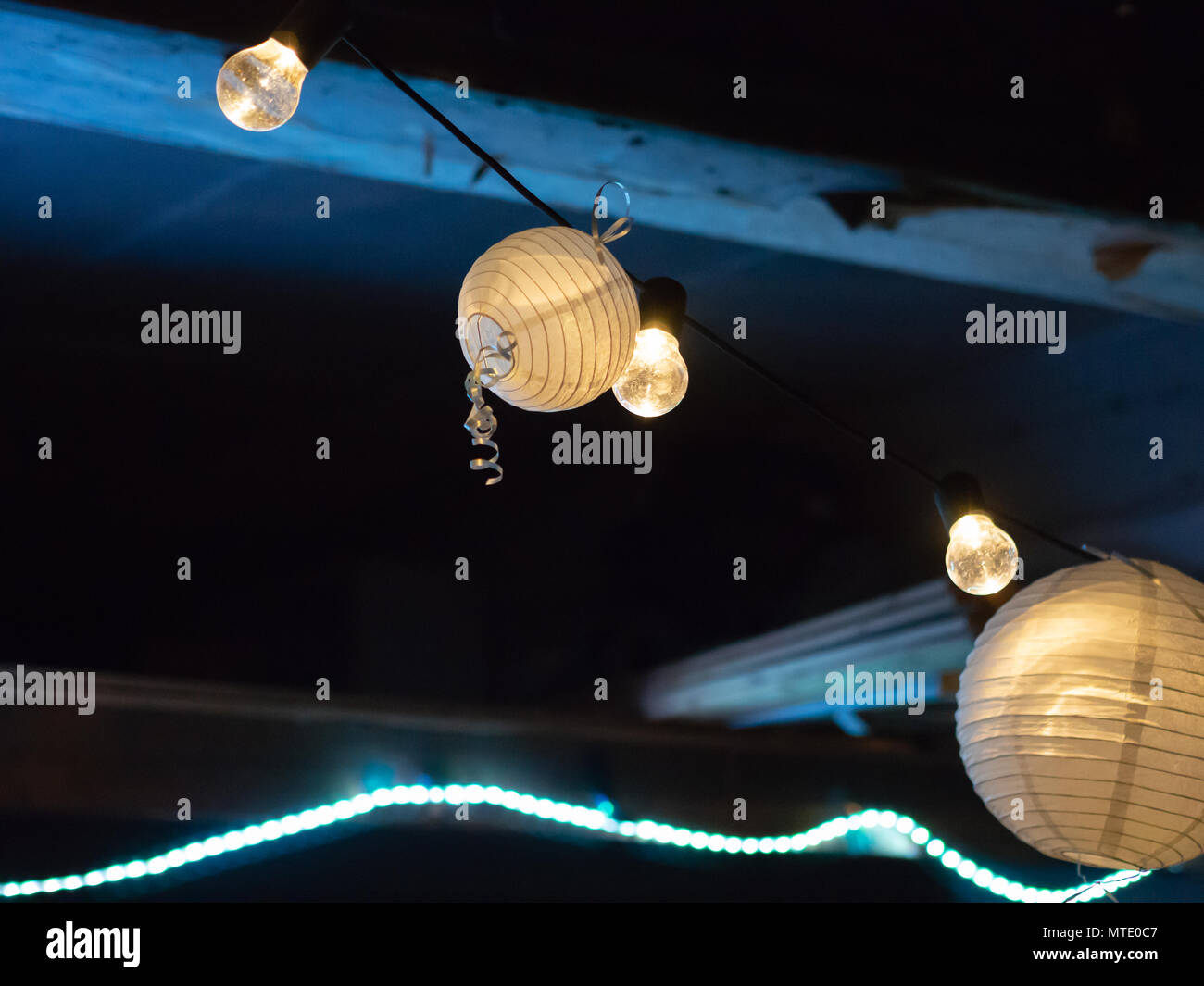 Paper lights strung up for a party at night Stock Photo - Alamy