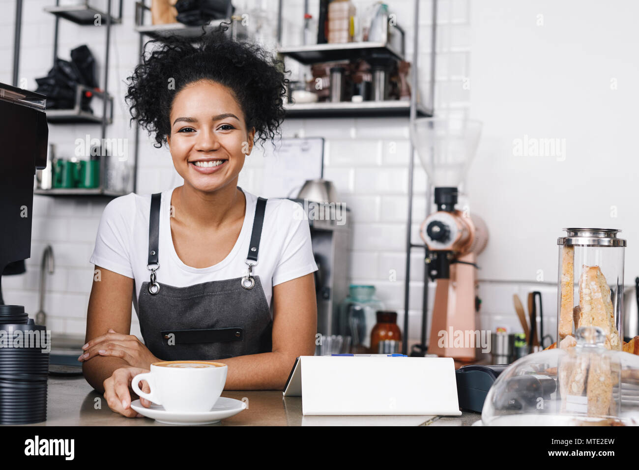 Portrait of a young curly waitress in a cafeteria Stock Photo - Alamy