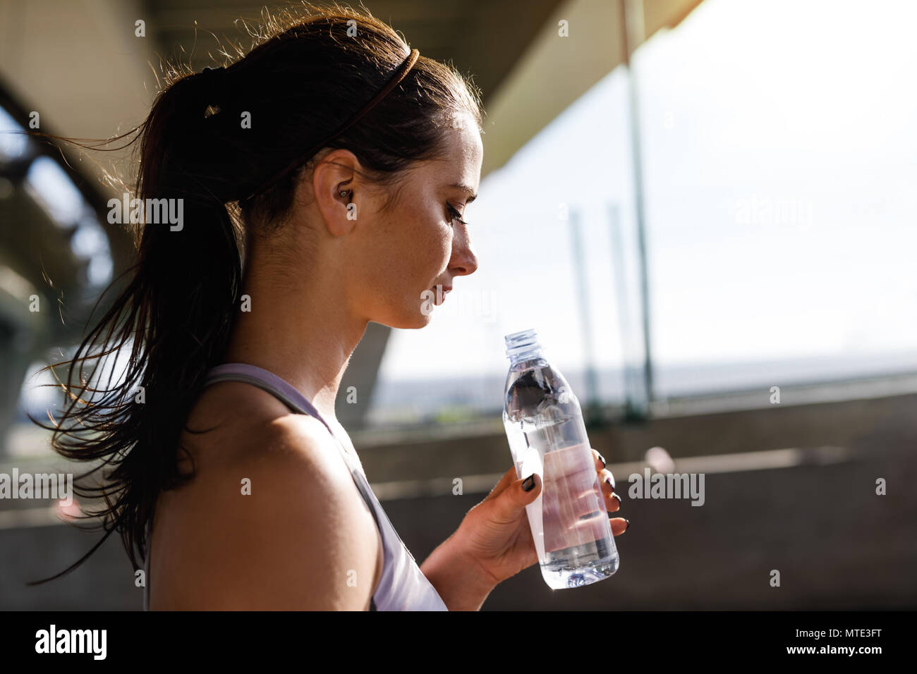 Female athlete taking a break during workout., drinking water from a ...