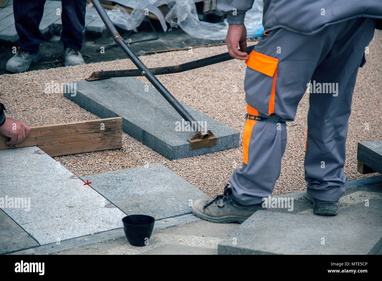 Builder workers lay large paving slabs, install paver sidewalk Stock ...