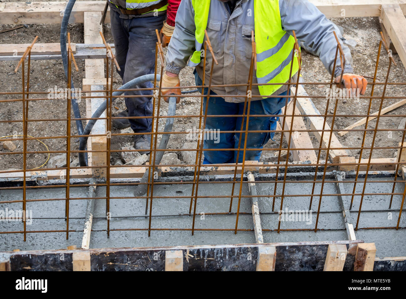 Builders crew using air poker to remove entrained air in poured ...