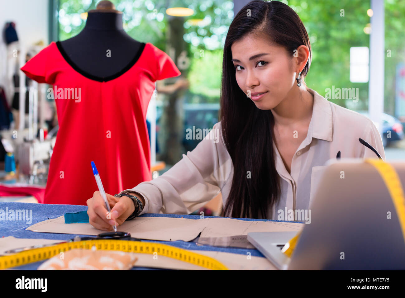 Asian fashion designer preparing drafts for cut-outs Stock Photo - Alamy