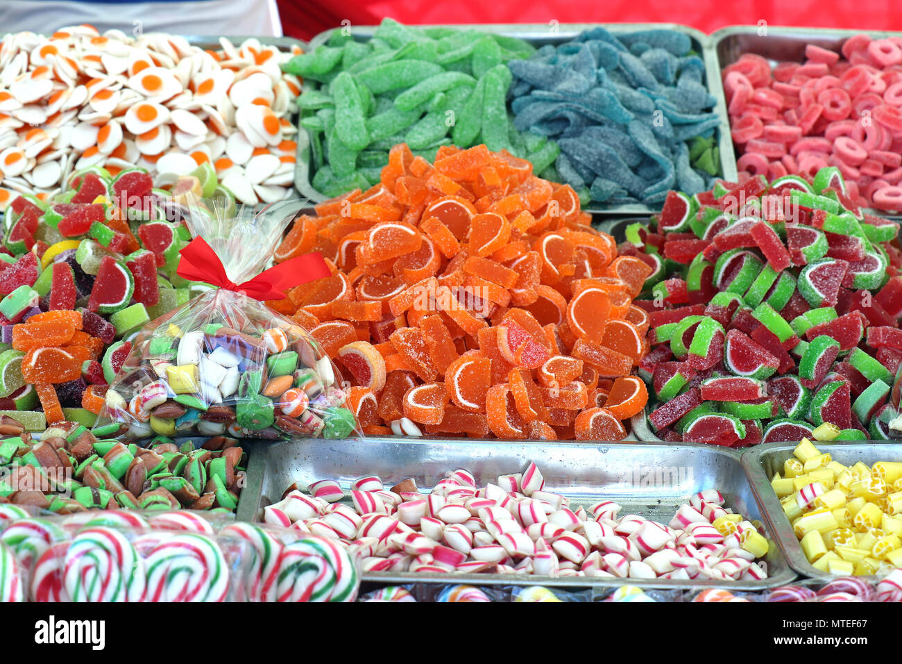 Piles of colorful sweets sold on fair market stall Stock Photo - Alamy
