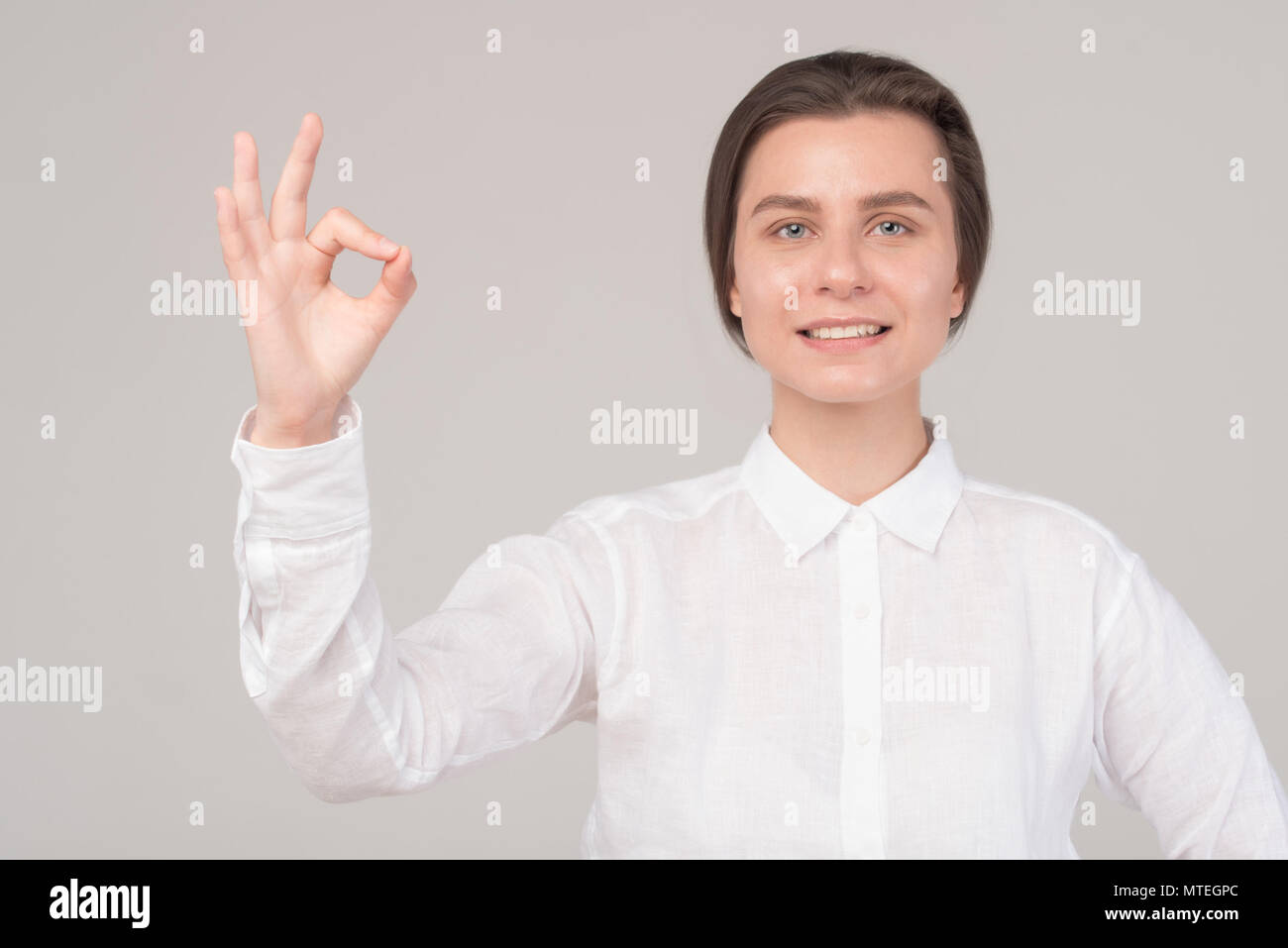 Young happy business girl shows OK sign isolated Stock Photo - Alamy