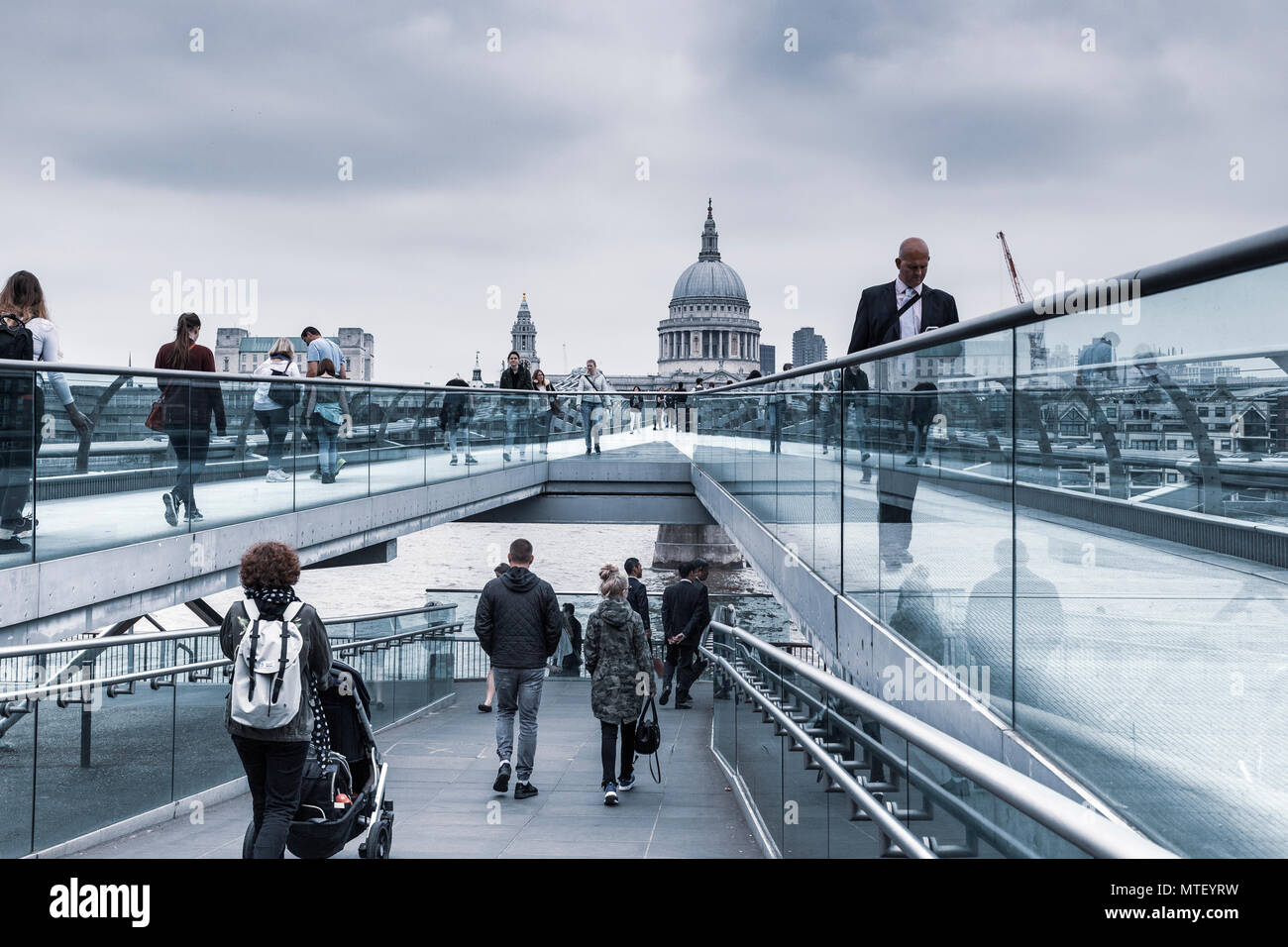 People walking across Millennium Bridge in London, with St Paul's ...