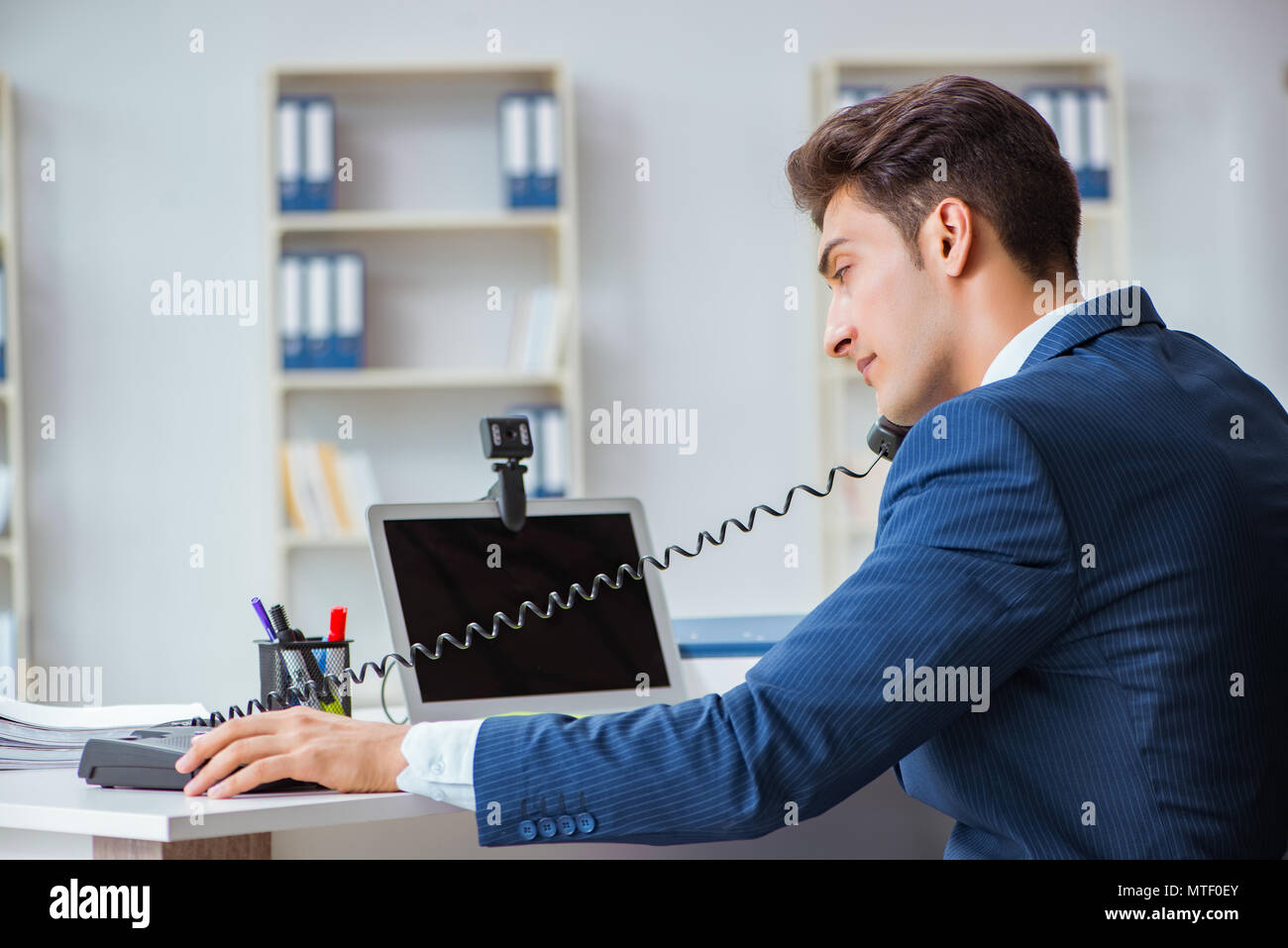 Young help desk operator working in office Stock Photo - Alamy