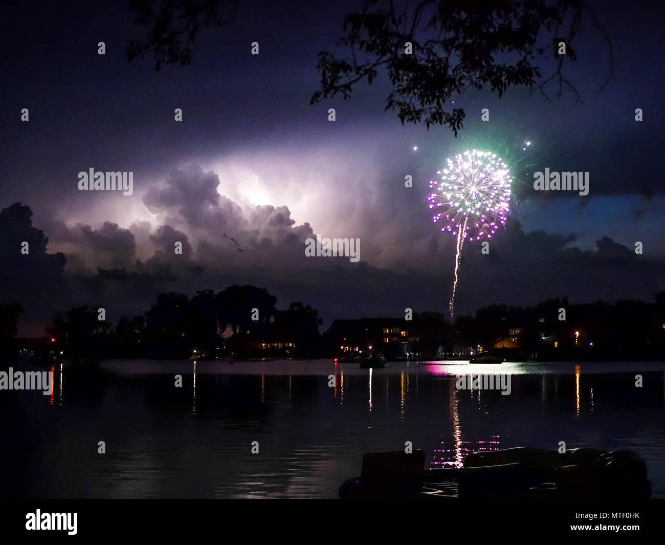 Fireworks exploding in the distance with a lightning storm happening ...