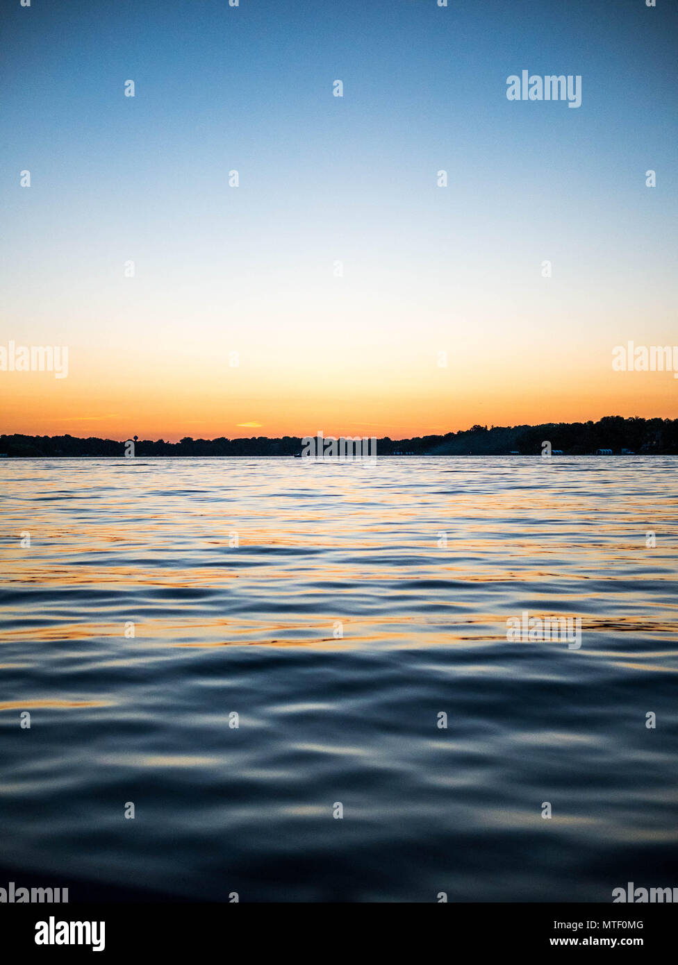 Sun setting over the lake Stock Photo - Alamy