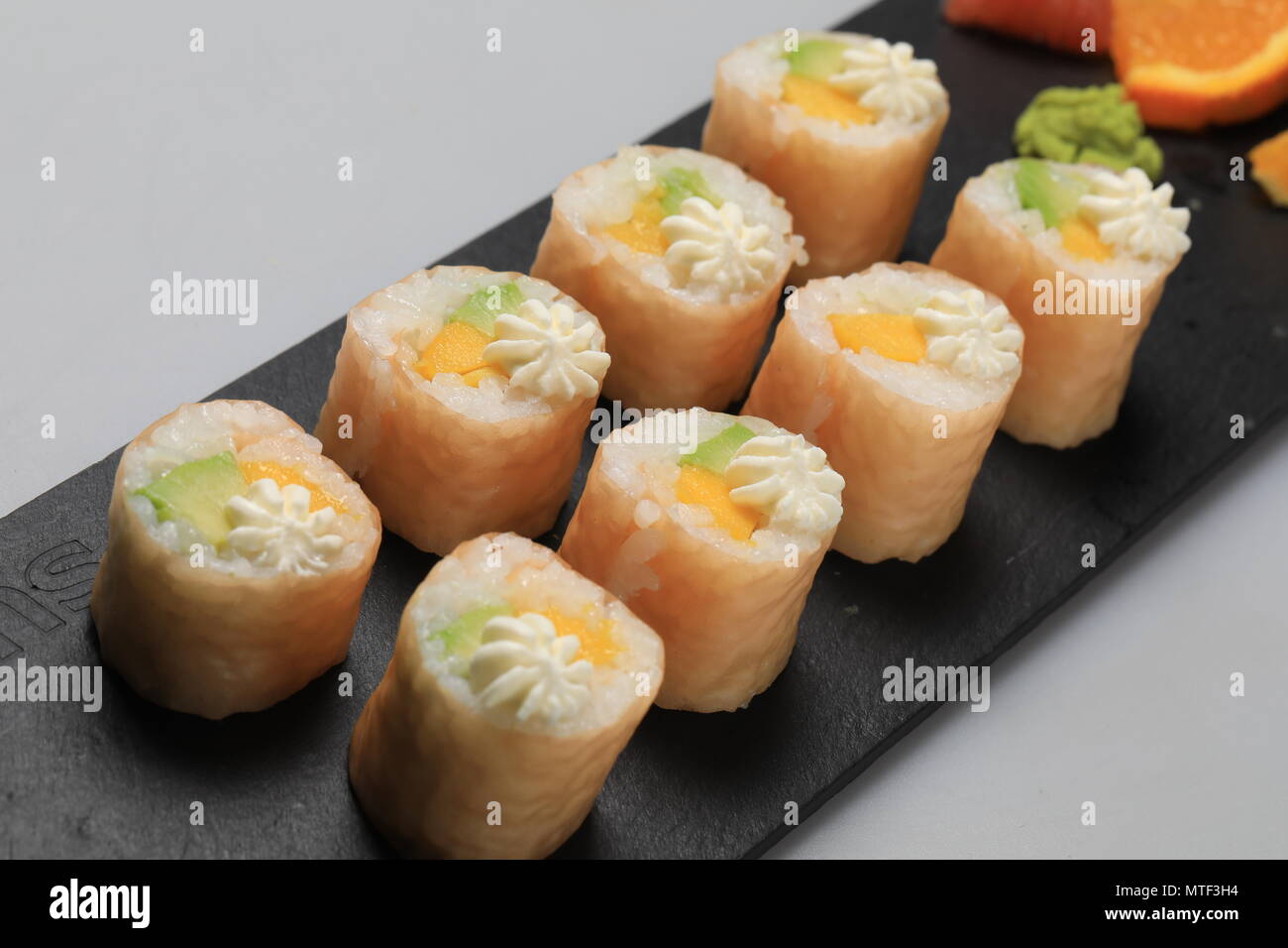 Yellow and orange sushi rolls Stock Photo - Alamy