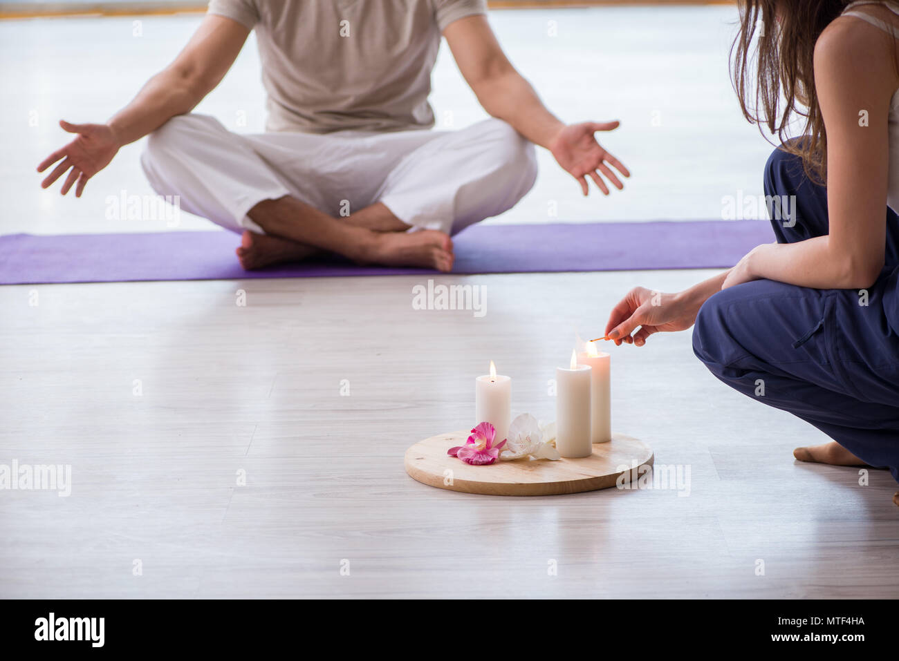 Personal coach helping during yoga session Stock Photo - Alamy