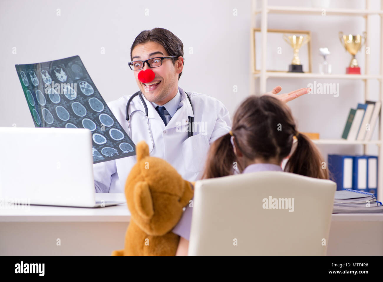 Funny pediatrician with little girl at regular check-up Stock Photo - Alamy