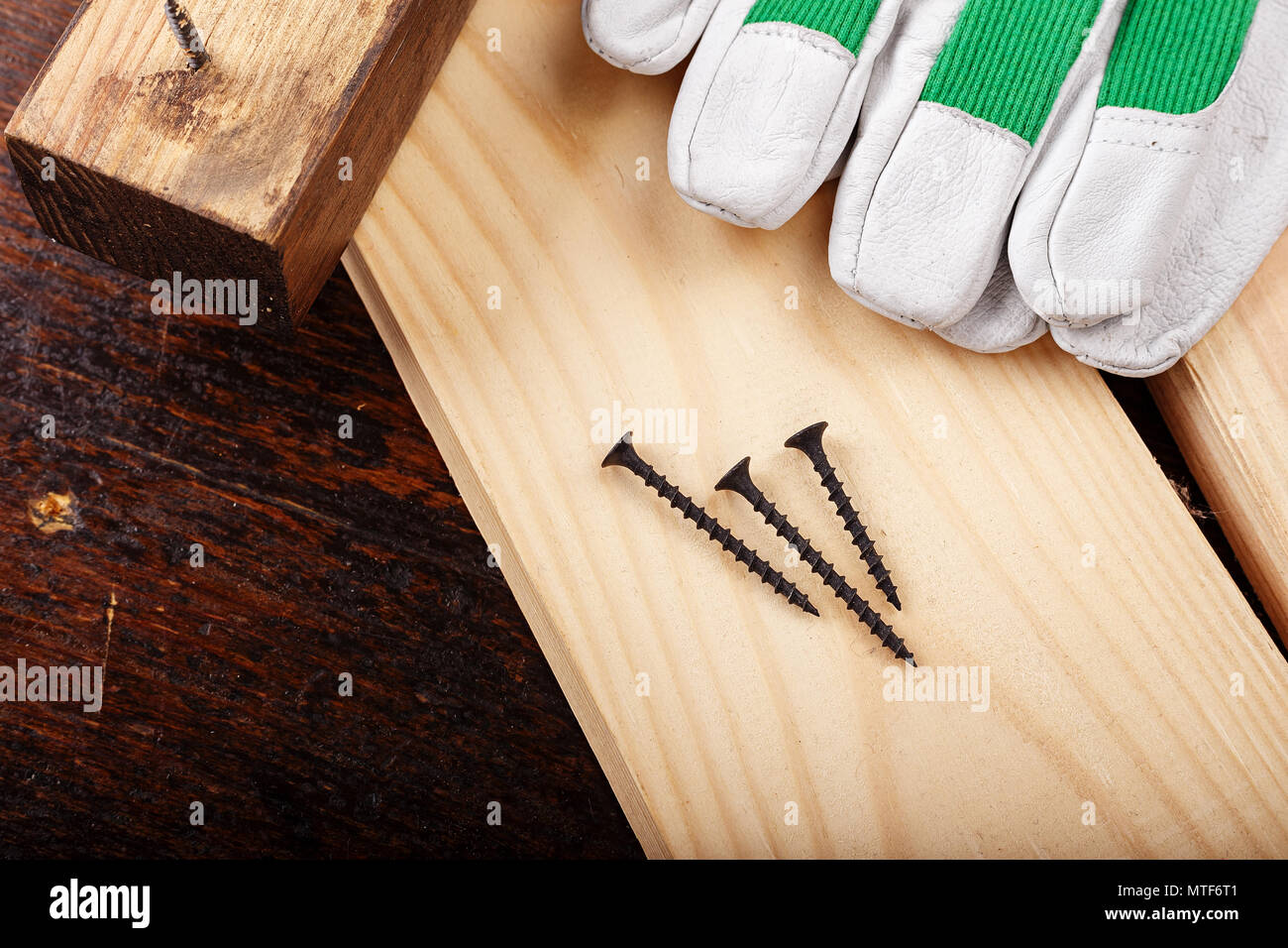 Nails on a log, next to carpenter's working gloves, horizontal photo ...