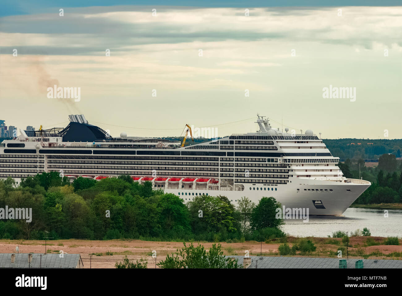 Big white cruise liner sailing past the cargo port Stock Photo - Alamy