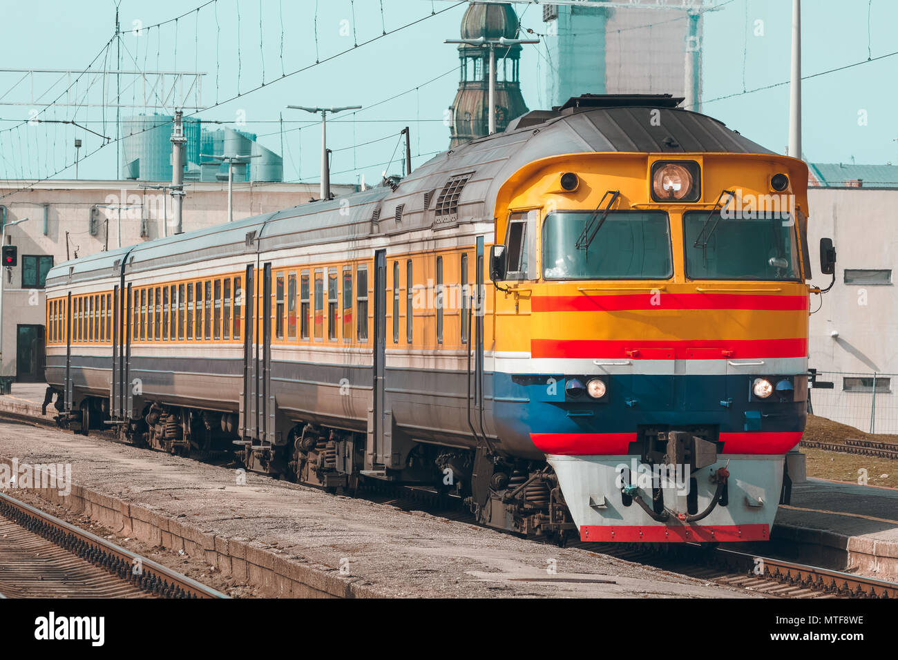 Old yellow passenger diesel train moving at the terminal Stock Photo ...