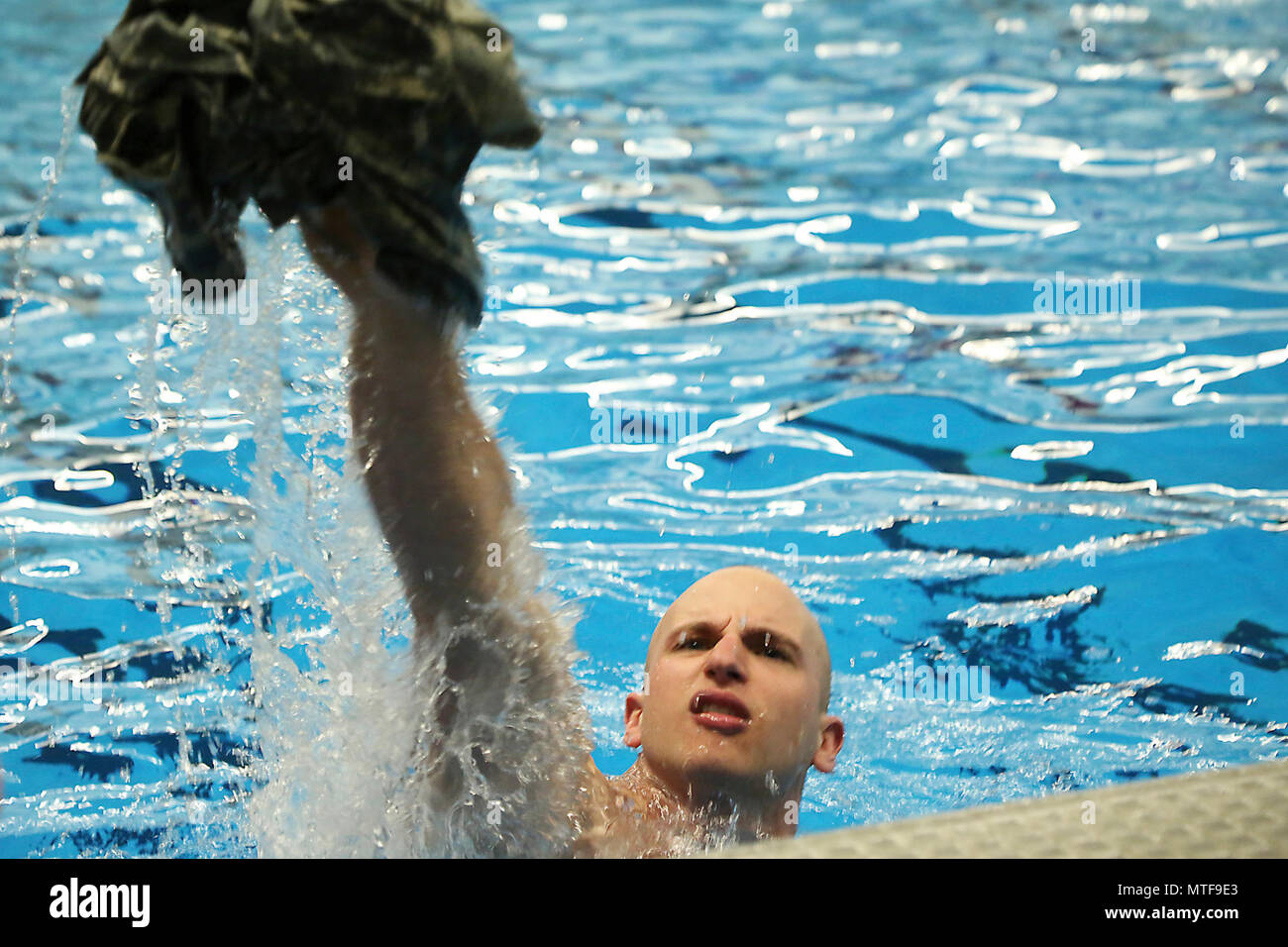 A U.S. Soldier with the 20th CBRNE Command, throws his uniform top over ...