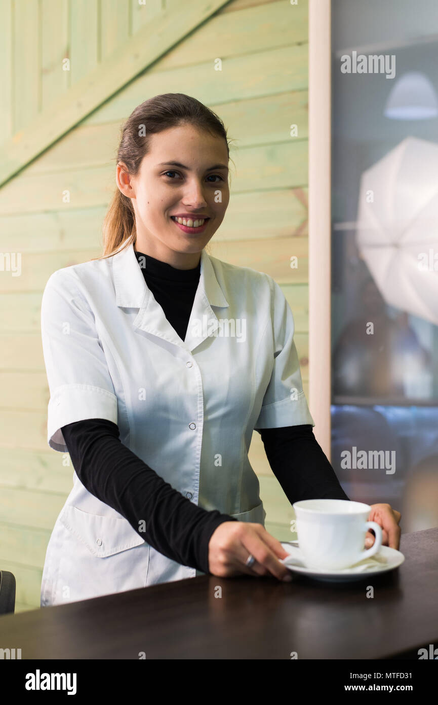 Female nurse at desk making coffee working in a modern office Stock ...