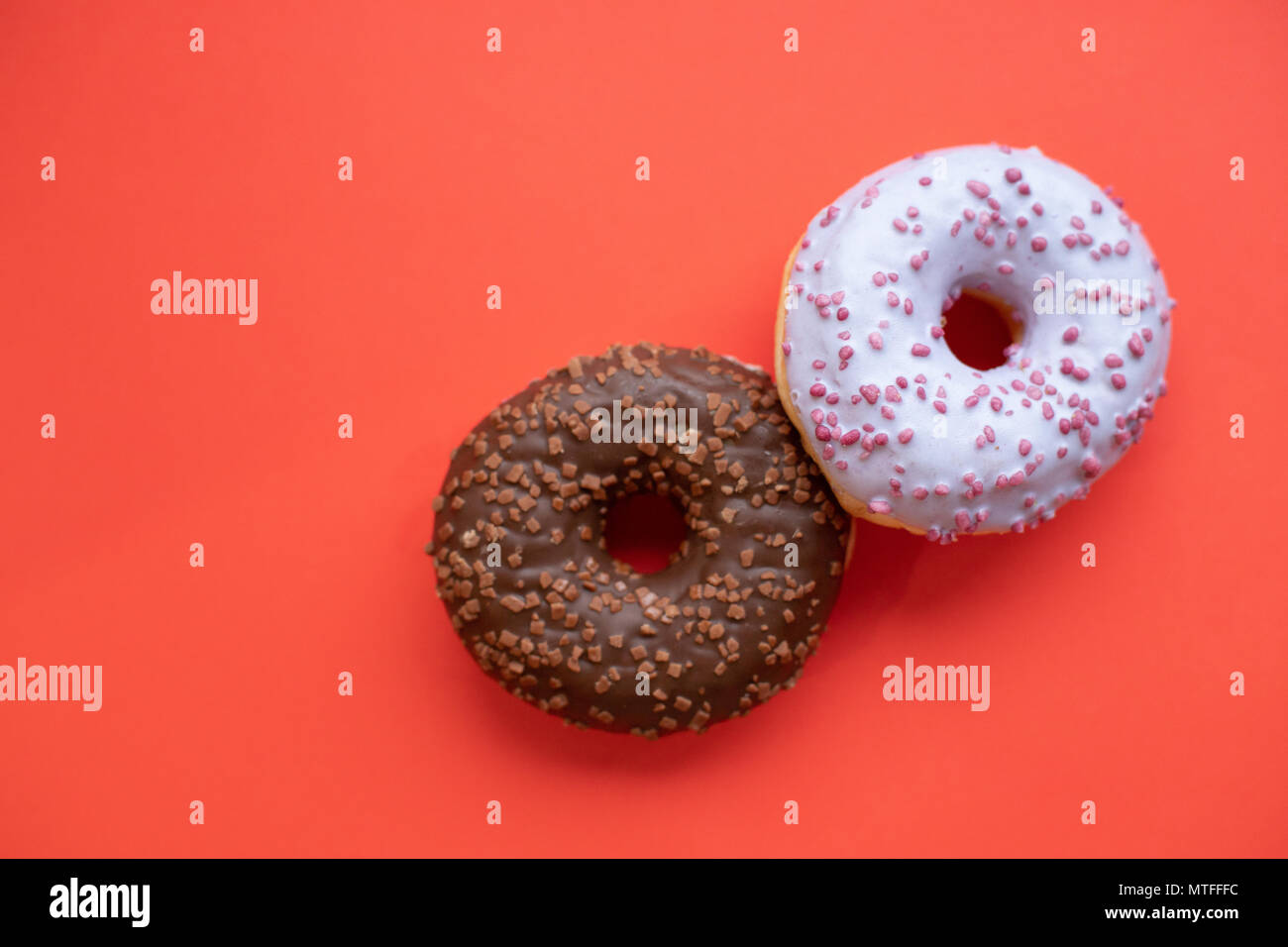 two glazed donuts isolated on red background.pastel color,pink and ...
