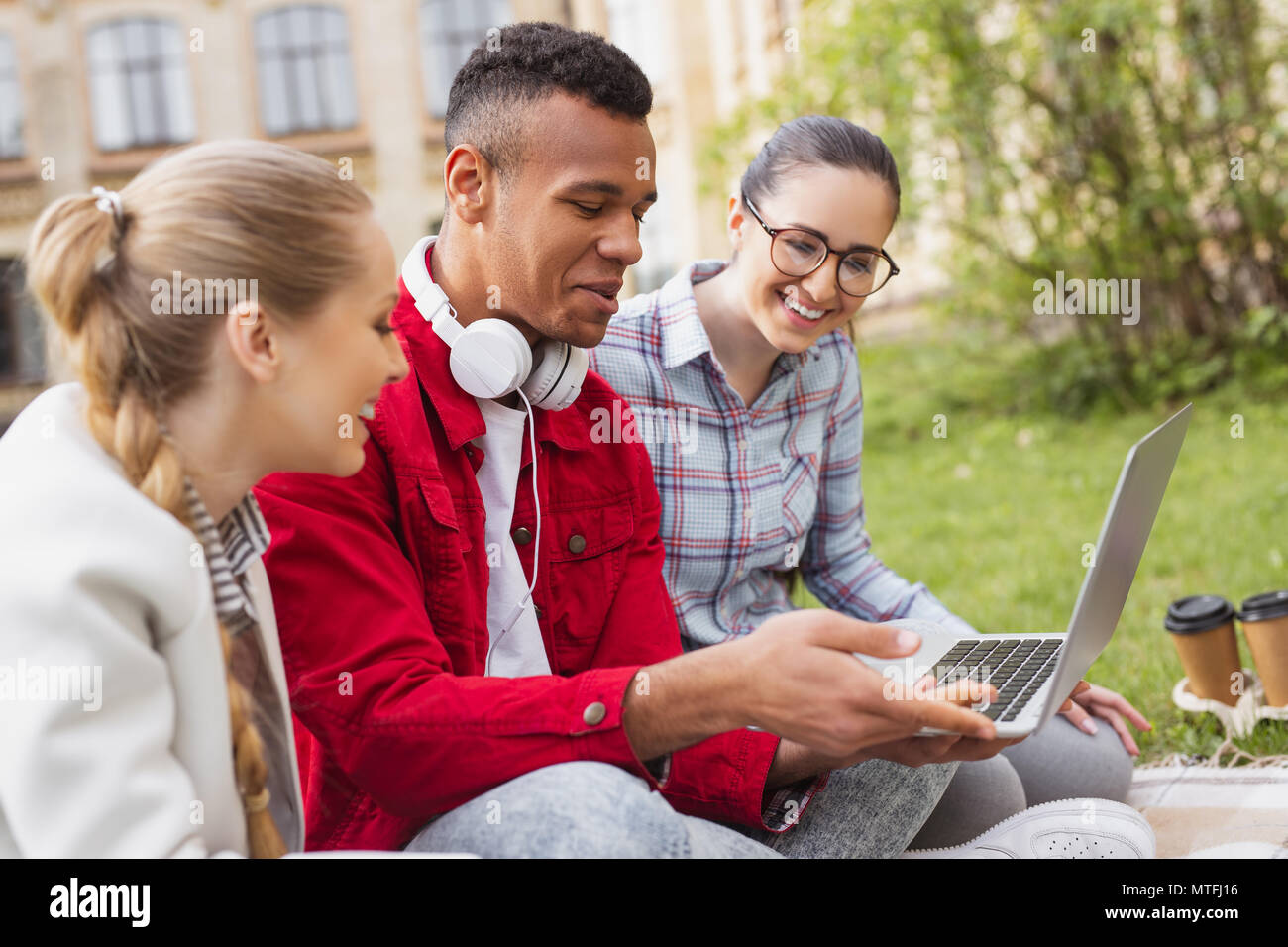 Smiling graduates laughing while communicating Stock Photo - Alamy