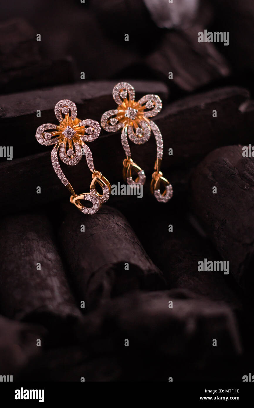 Diamond studded gold earrings Stock Photo - Alamy