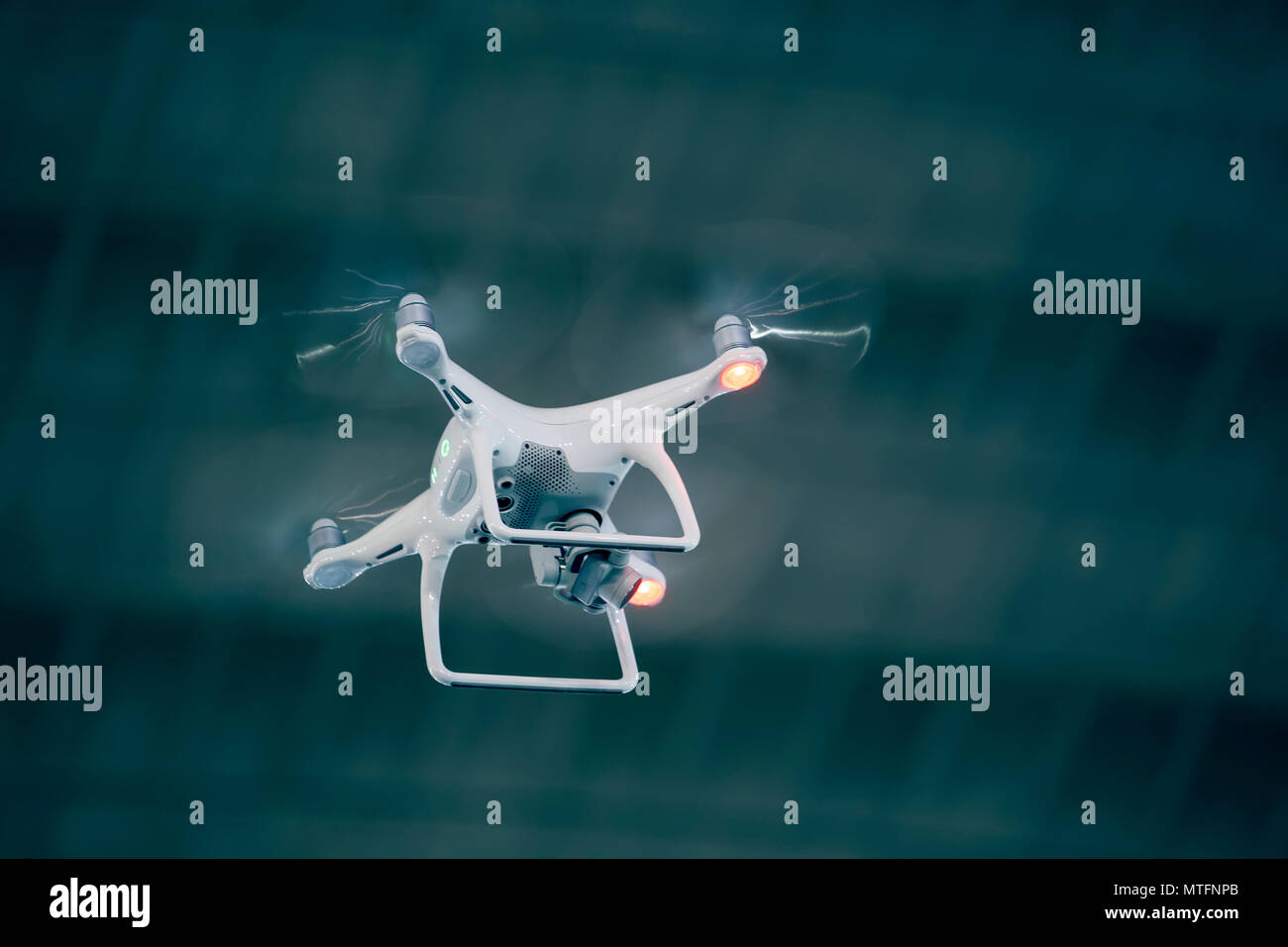 White drone with digital camera flying inside fair hall. Indoor flying ...