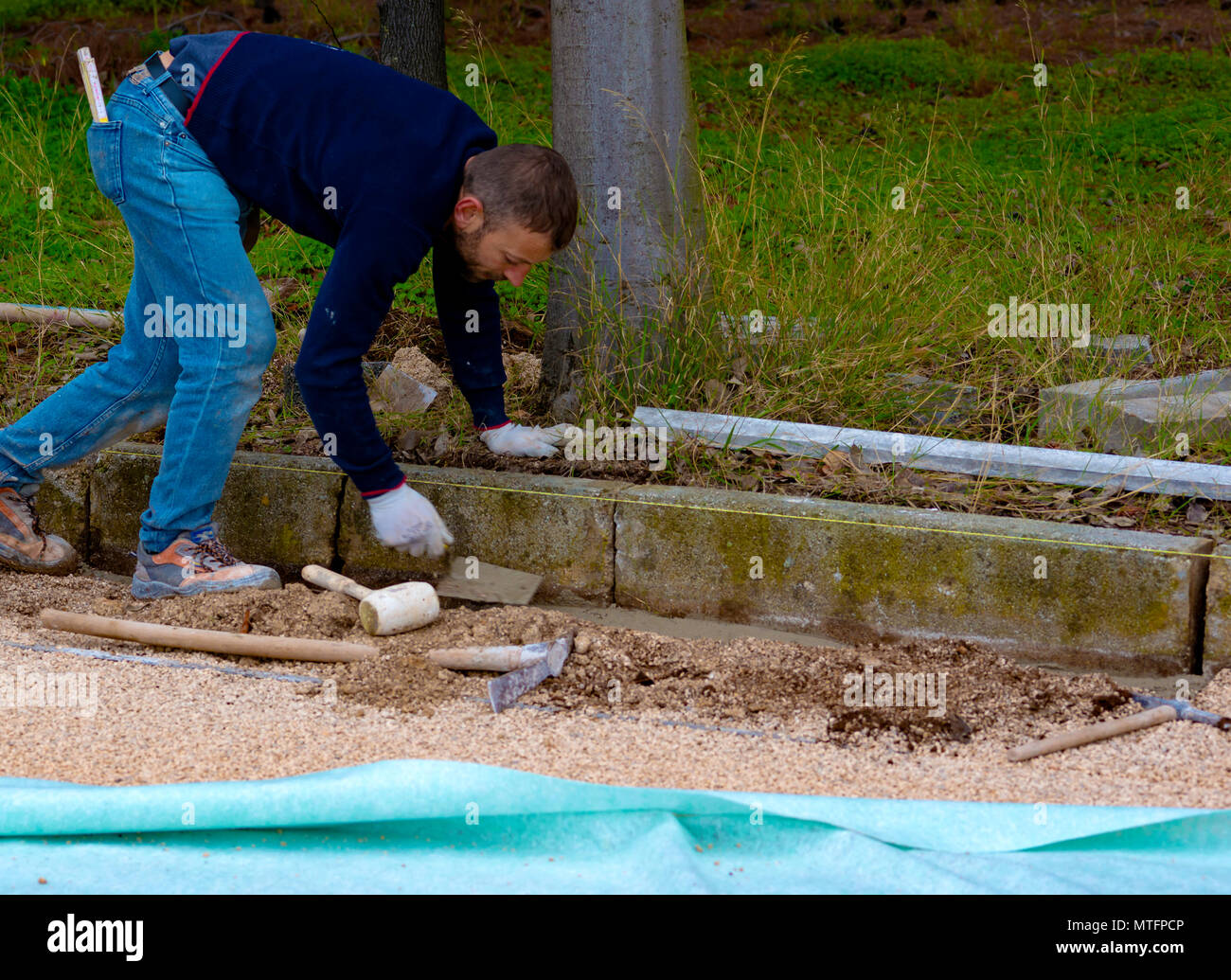 Construction site - Workers laying concrete curbs Stock Photo - Alamy