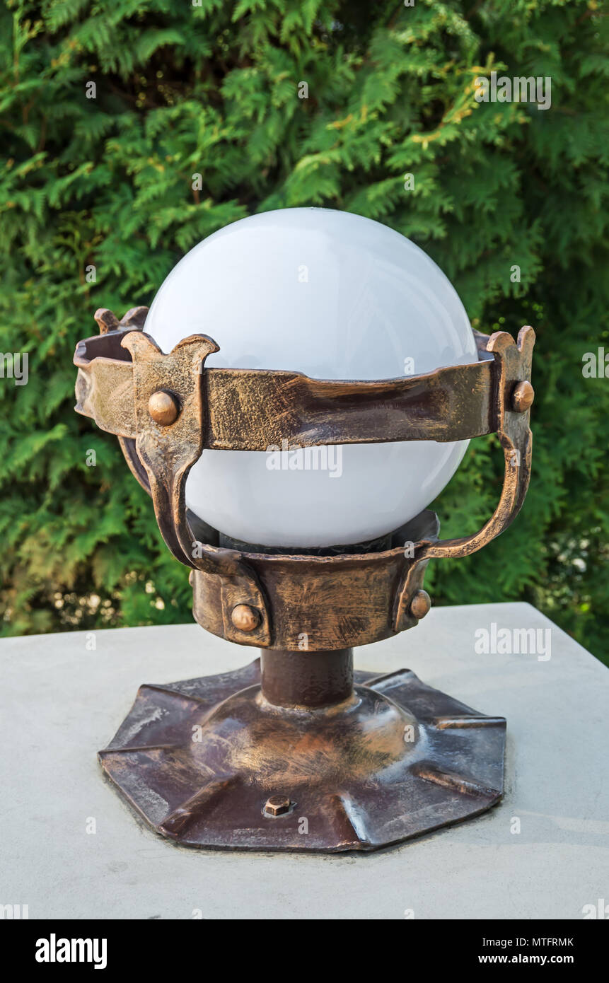 A round street lamp in a forged garment which is installed near the ...