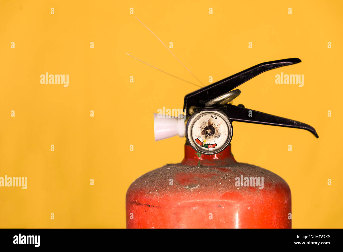 old dusty fire extinguisher on an orange background Stock Photo - Alamy