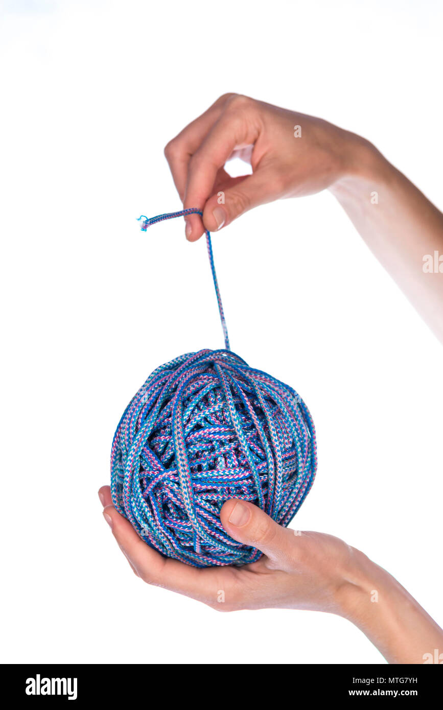 ball tangle of multi-colored rope on the palm of a woman on a white ...