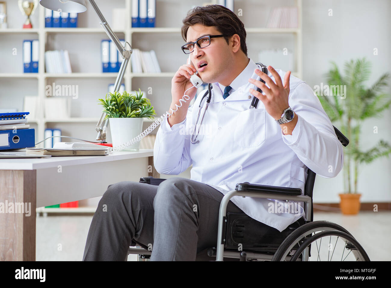 Disabled doctor on wheelchair working in hospital Stock Photo - Alamy