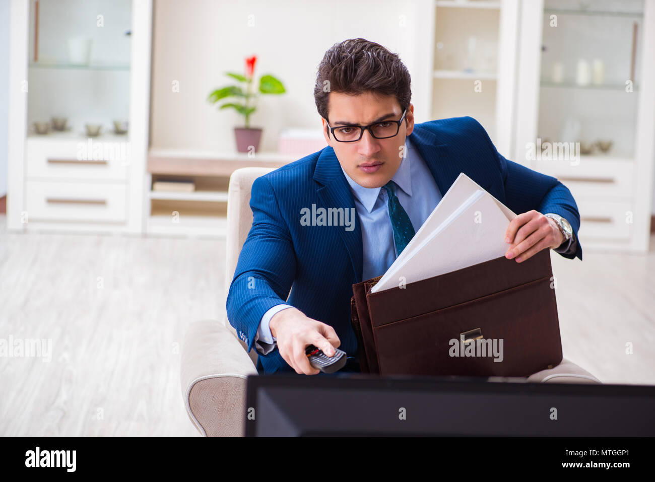 Businesman watching tv in office Stock Photo - Alamy