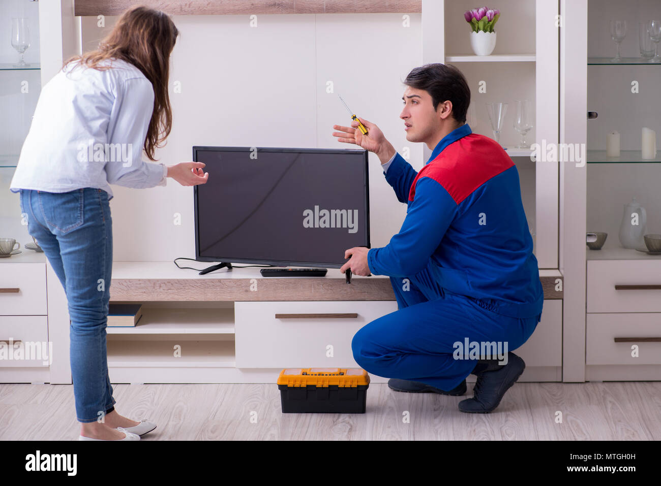 Tv repairman technician repairing tv at home Stock Photo - Alamy